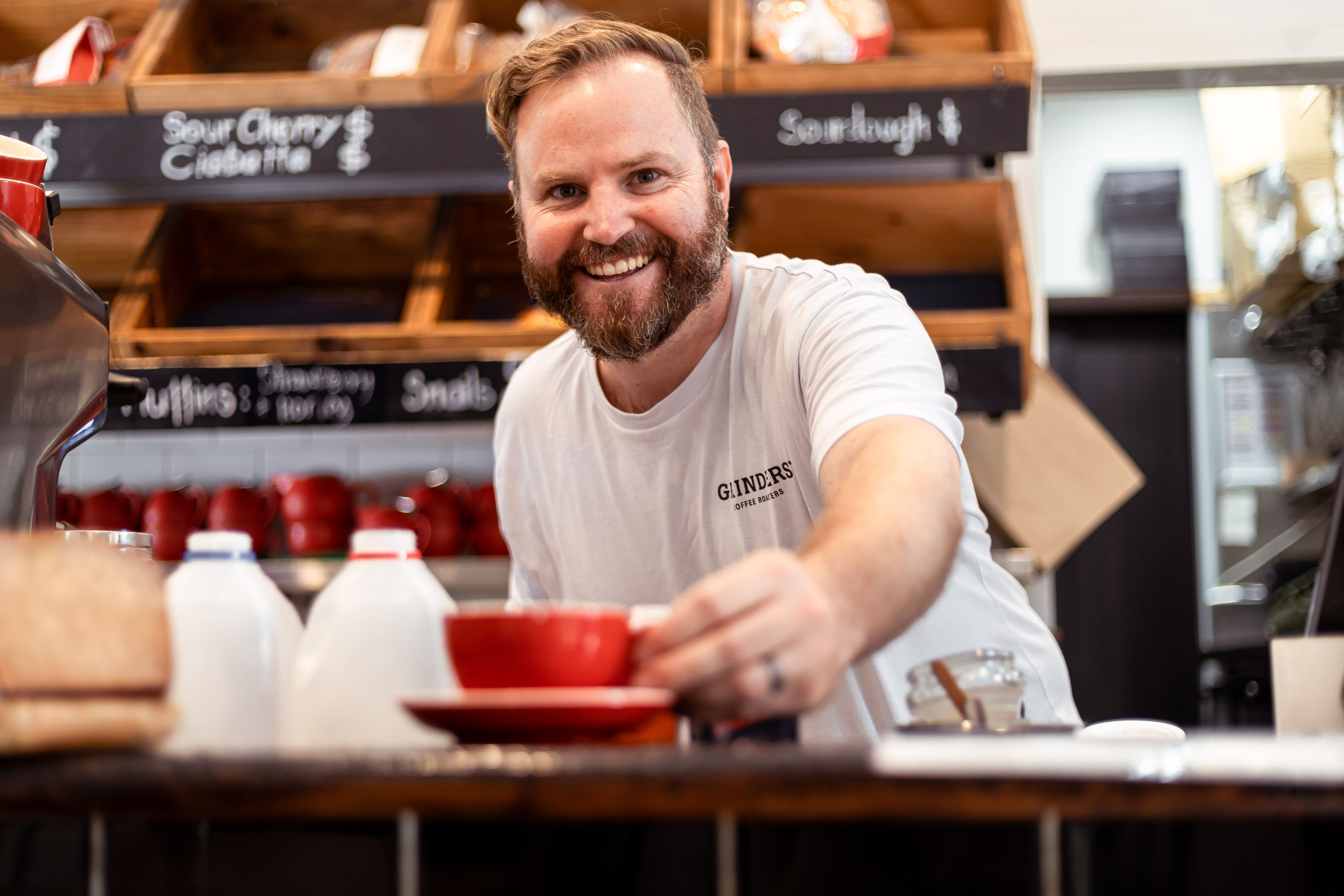Friendly Barista Serving Coffee in Cafe · Free Stock Photo