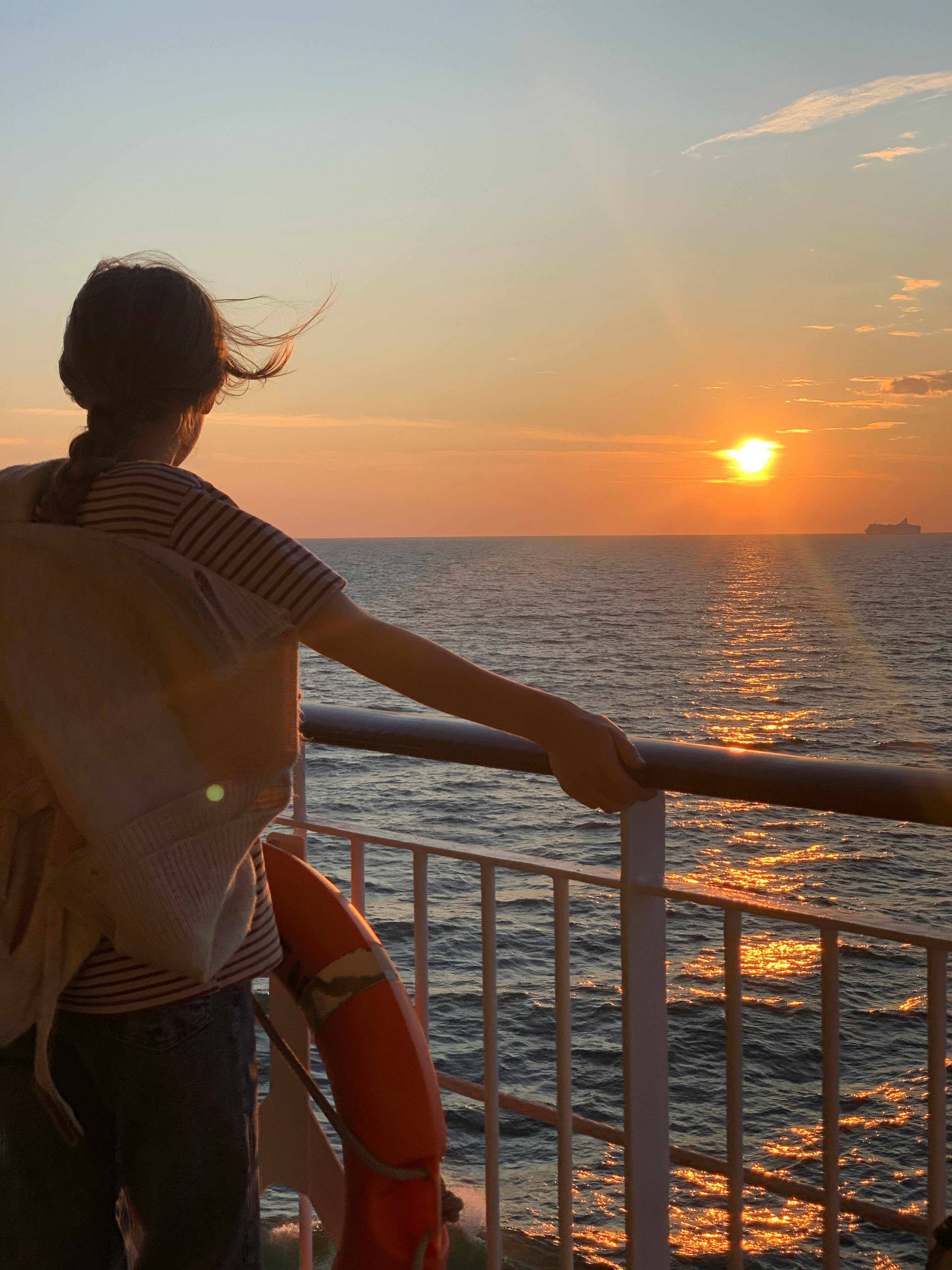 Serene Sunset View from a Ship Deck · Free Stock Photo