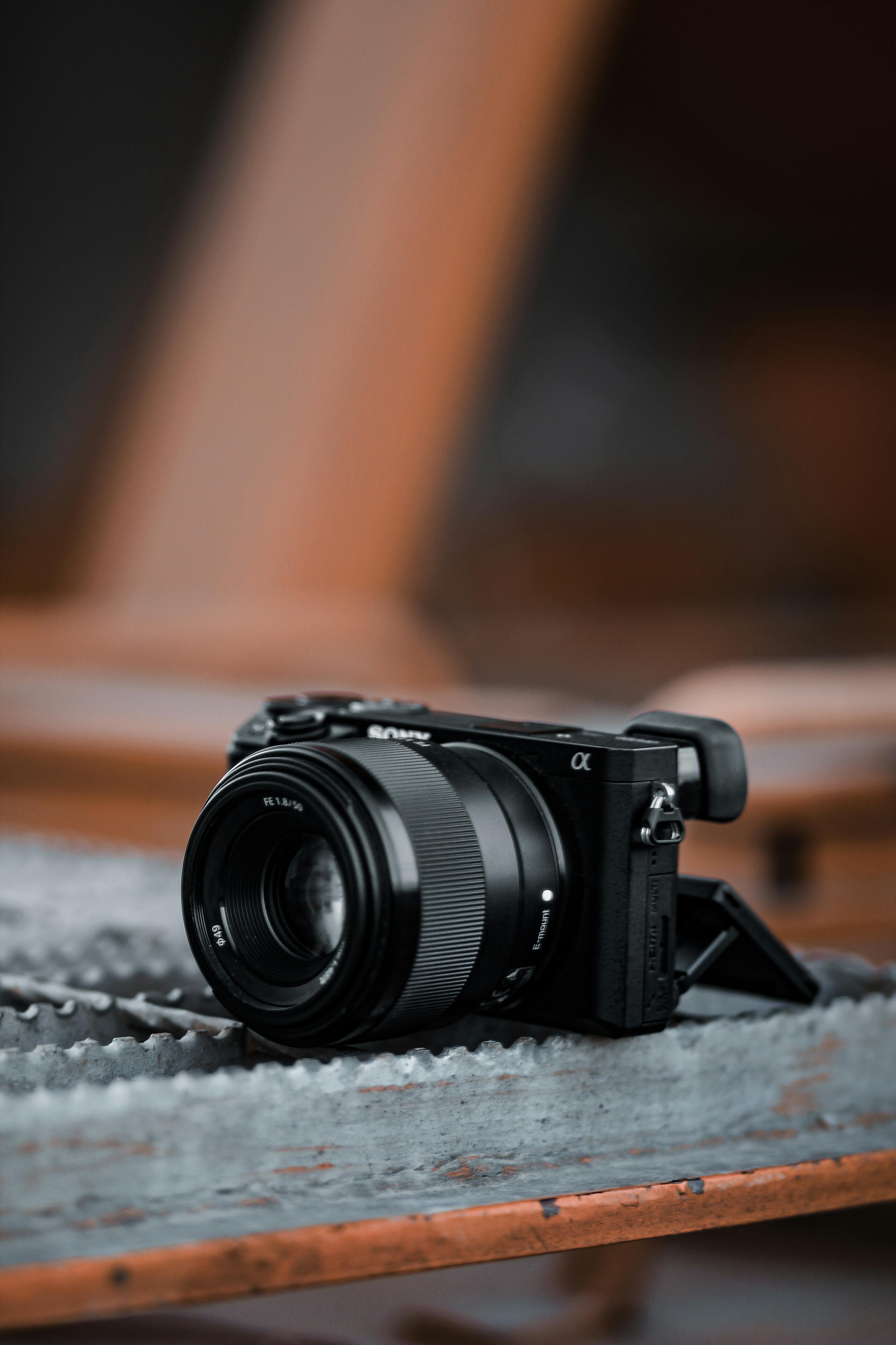 Close-up of a modern digital camera on a rustic surface · Free Stock Photo