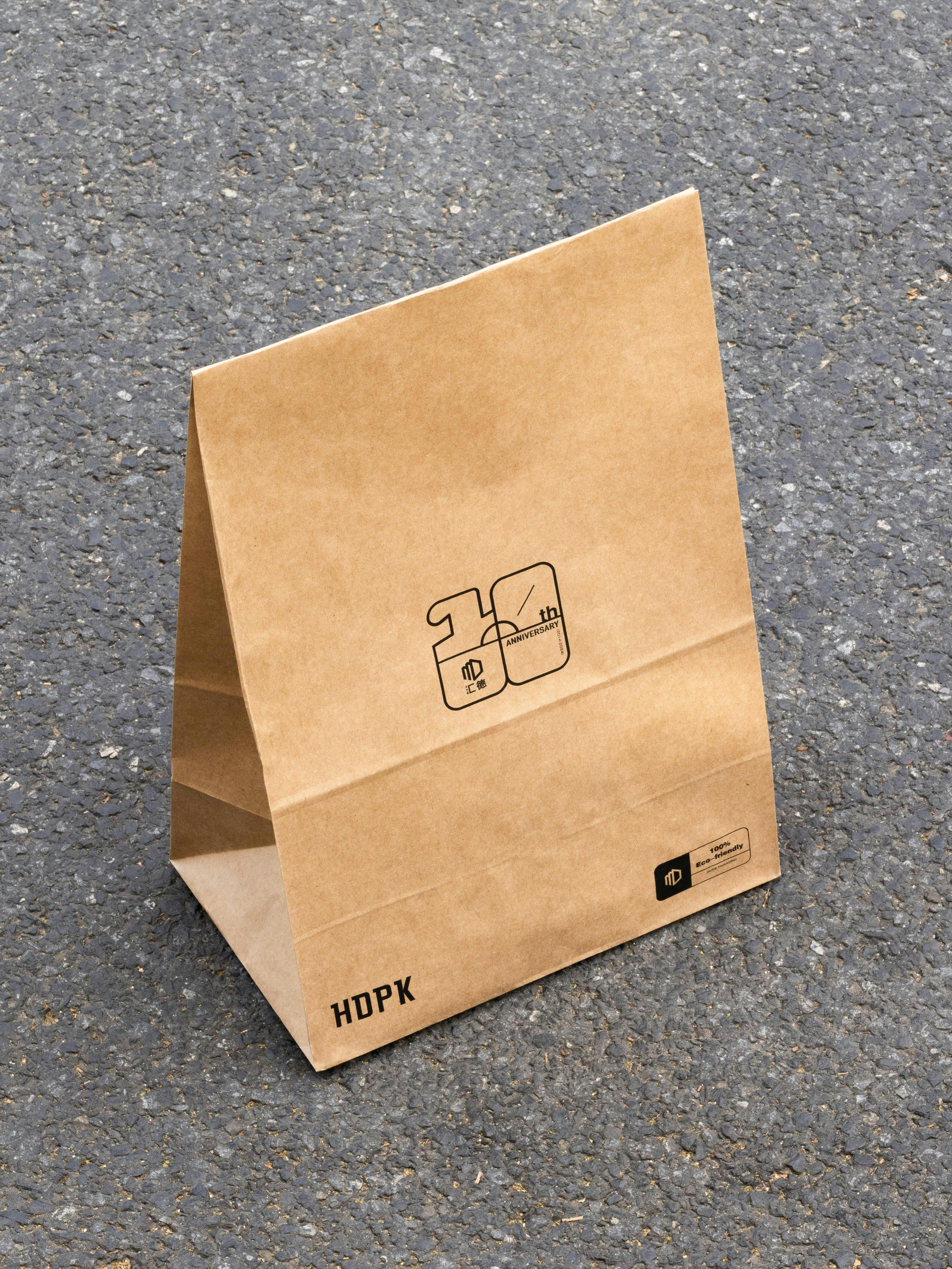 Eco-friendly Kraft Paper Bag on Pavement · Free Stock Photo