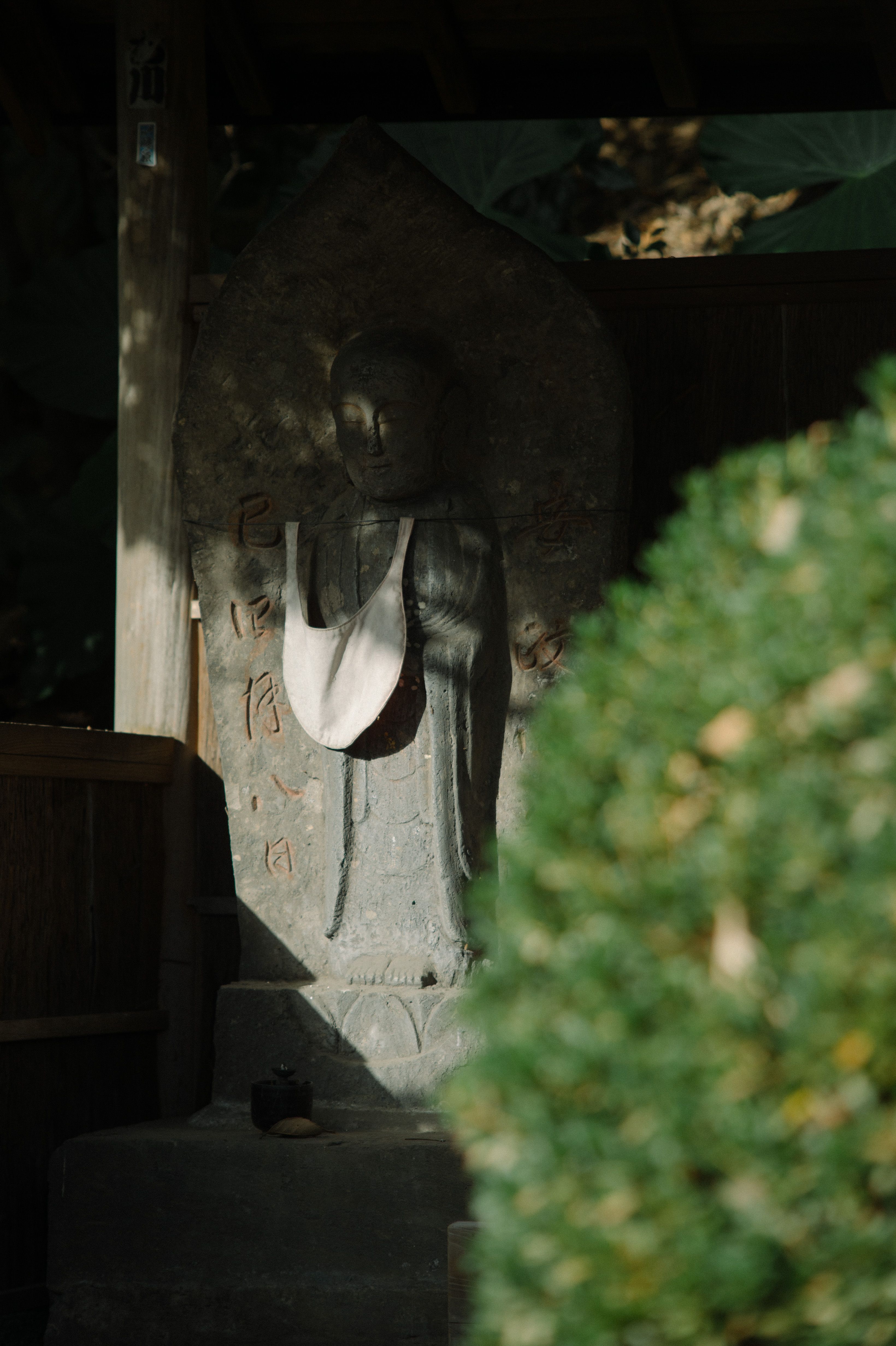 Serene Japanese Stone Buddha Statue Amidst Shadows · Free Stock Photo