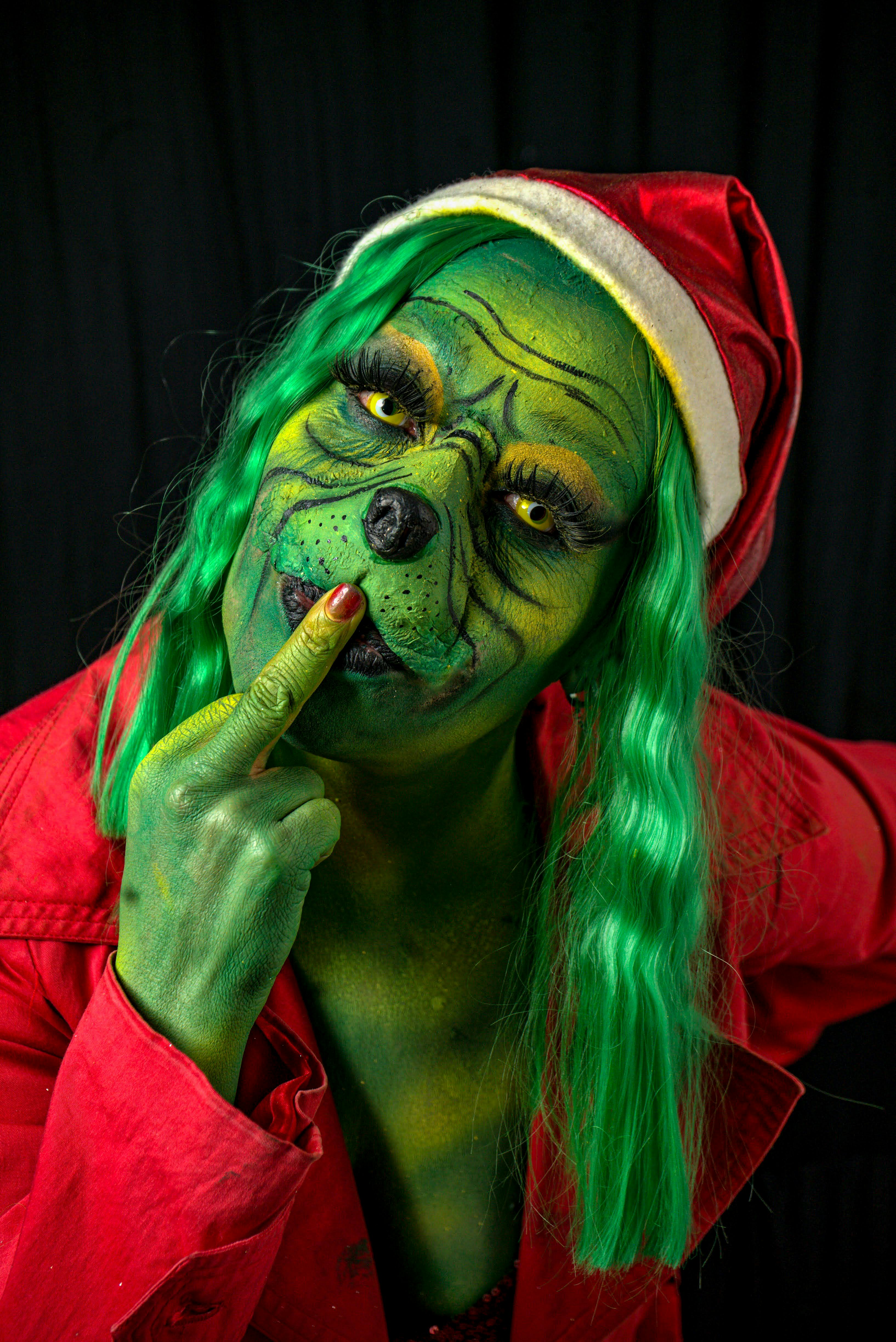 Festive Grinch Costume with Green Makeup and Santa Hat · Free Stock Photo