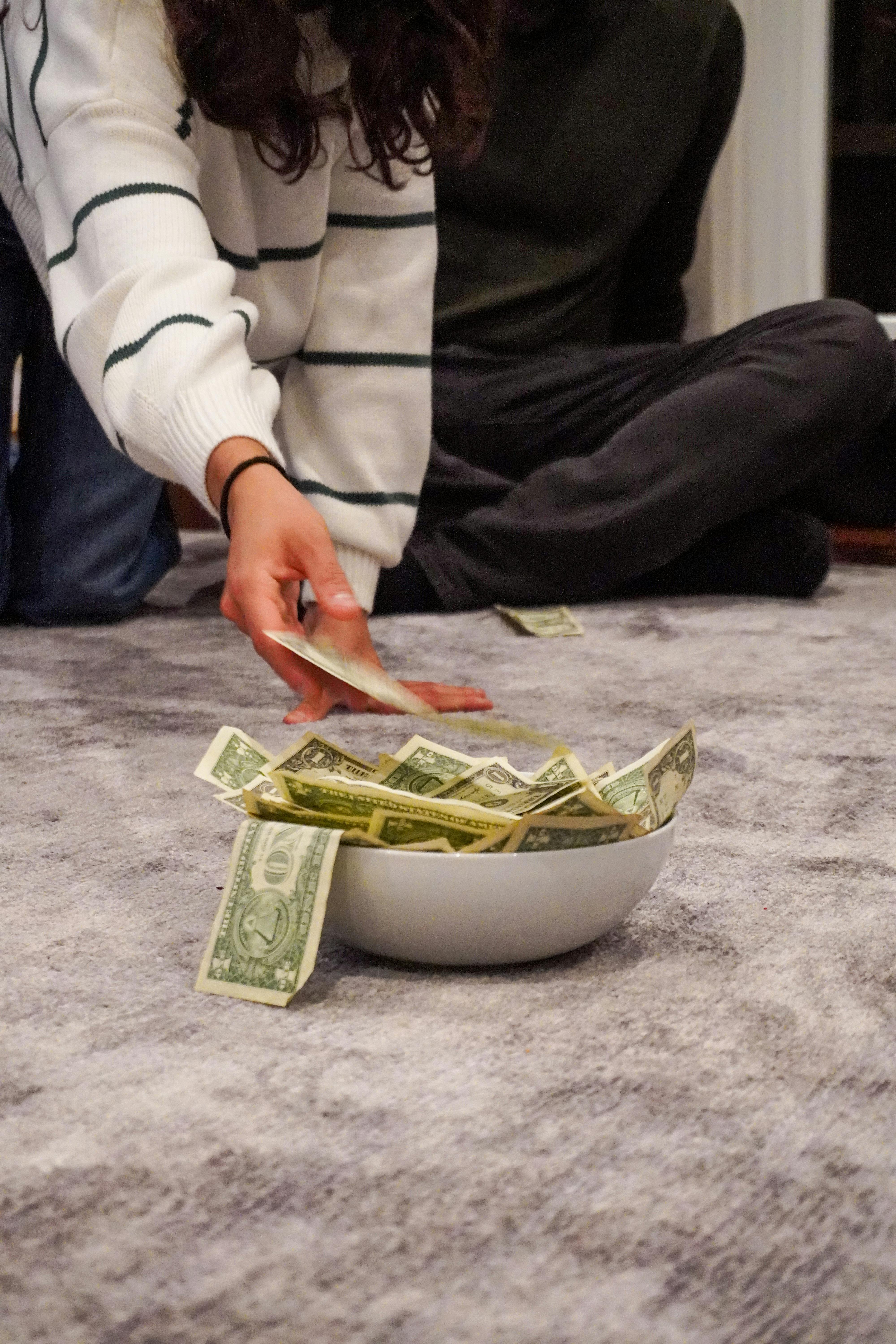 Person Collecting Dollar Bills in Indoor Game · Free Stock Photo
