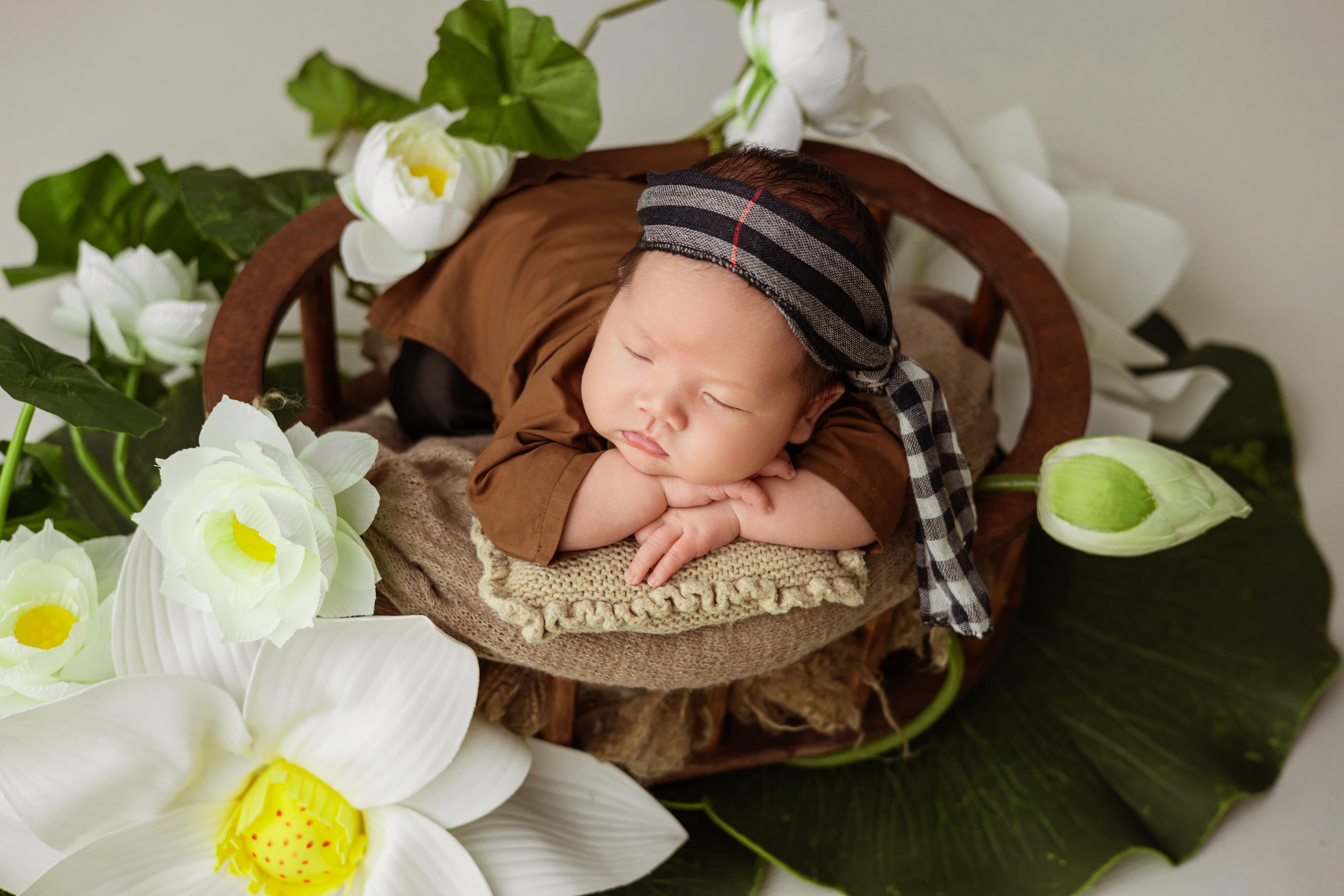 Peaceful Newborn Surrounded by Lotus Flowers · Free Stock Photo