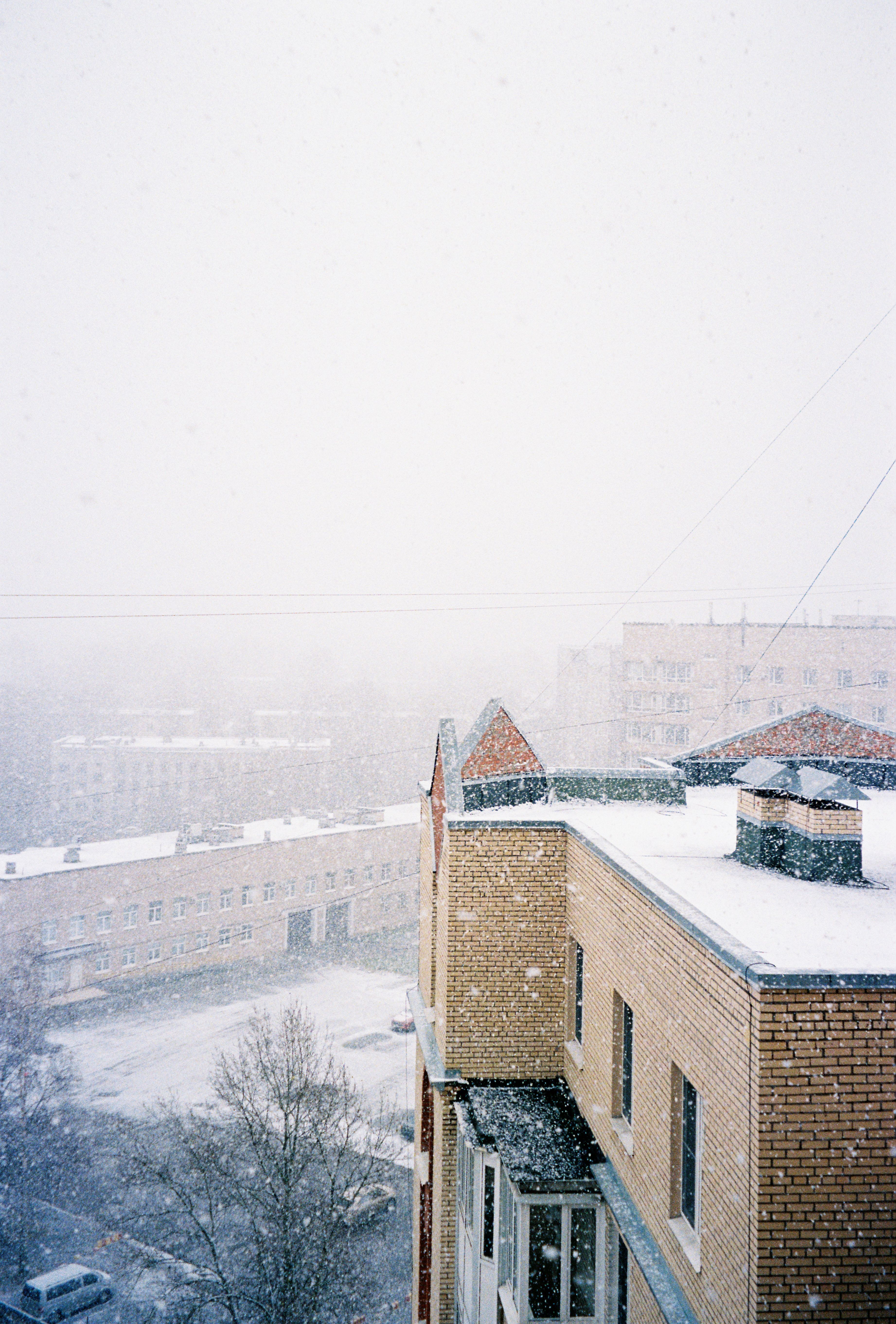 Urban Brick Building During Snowfall in Winter · Free Stock Photo