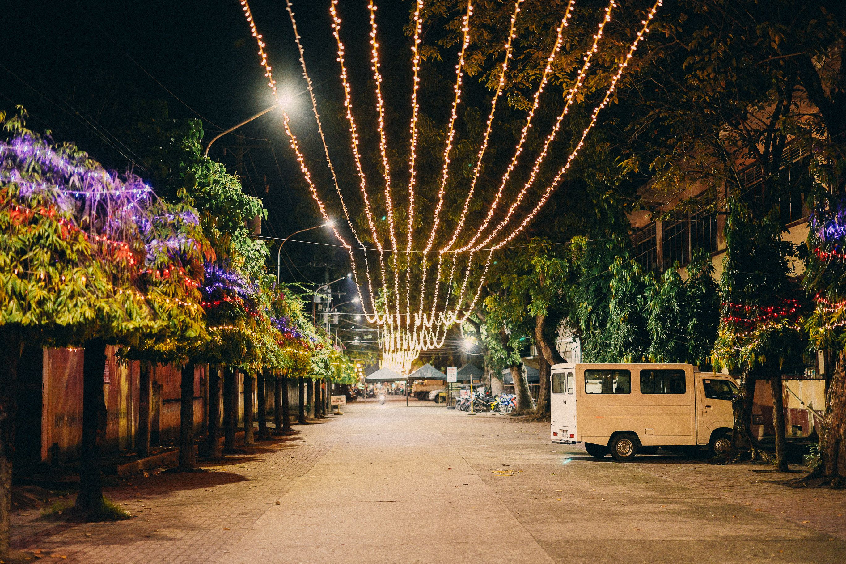 Festive Street Illuminated with String Lights at Night · Free Stock Photo
