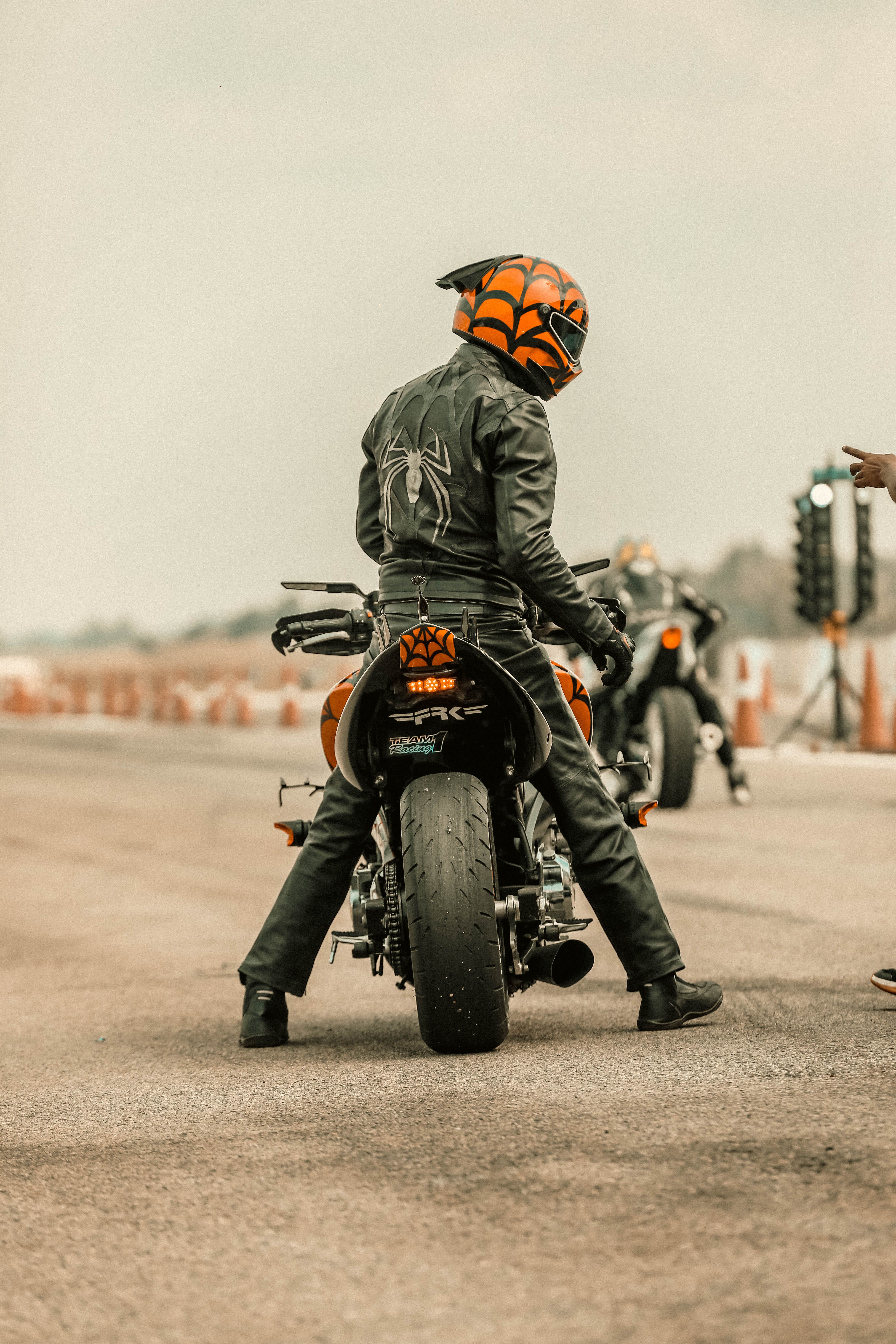 Motorcycle Racer in Spider-Themed Gear at Track · Free Stock Photo