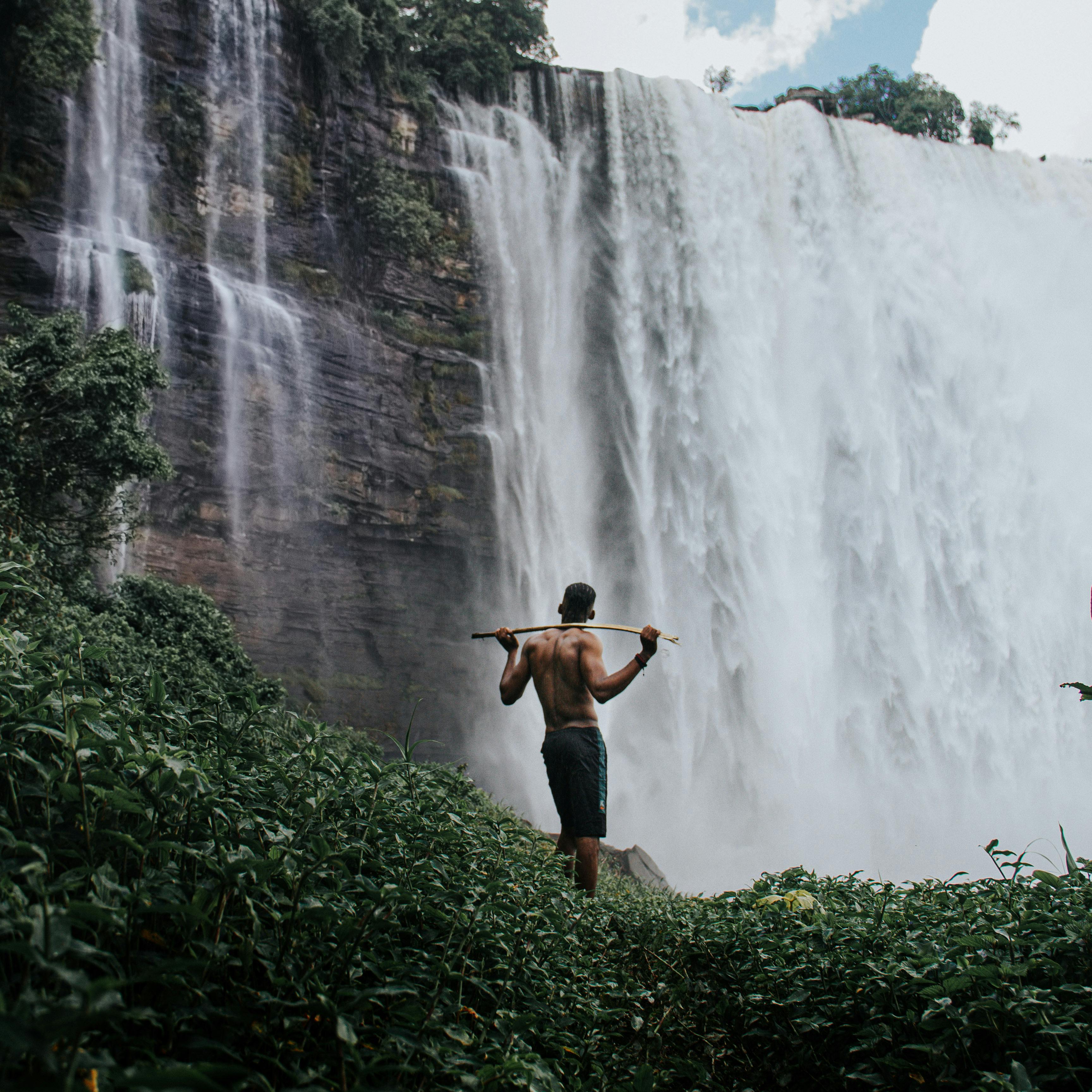 Adventurer at Majestic Waterfall in Malanje · Free Stock Photo