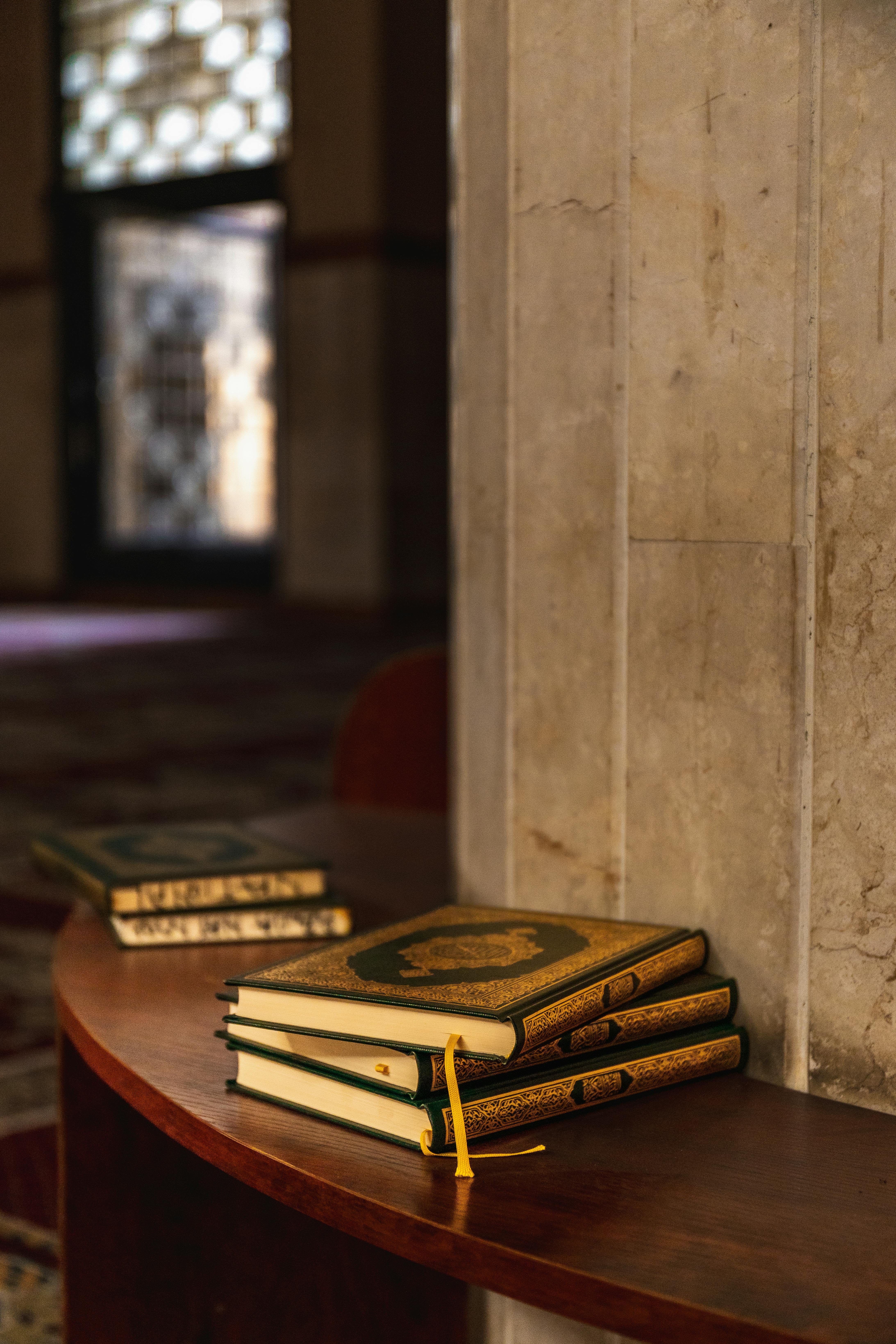 Stack of Quran Books on a Mosque Shelf · Free Stock Photo