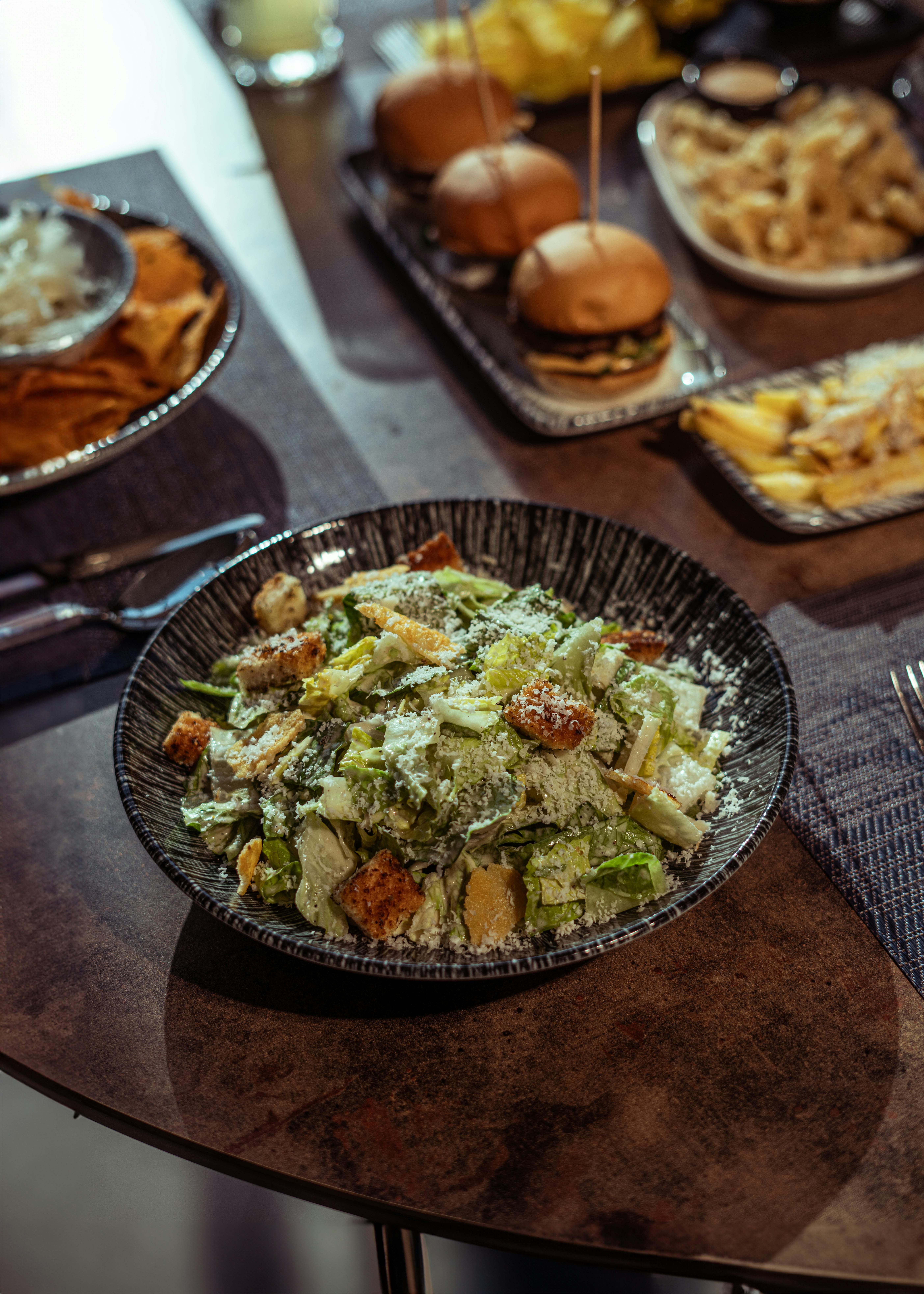 Delicious Caesar Salad and Burgers Buffet Table · Free Stock Photo