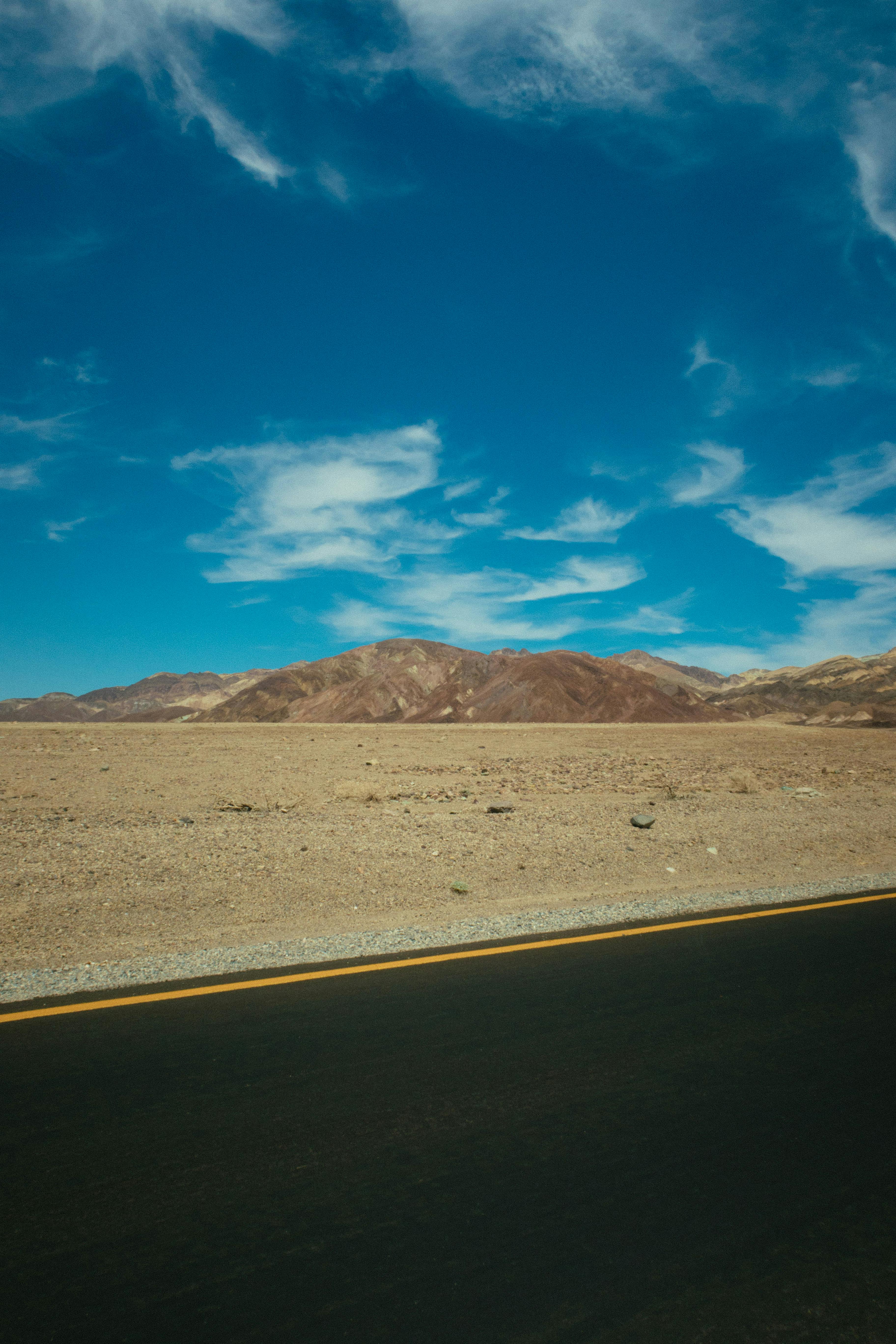 Highway Across Mountain Range Under Blue Sky · Free Stock Photo