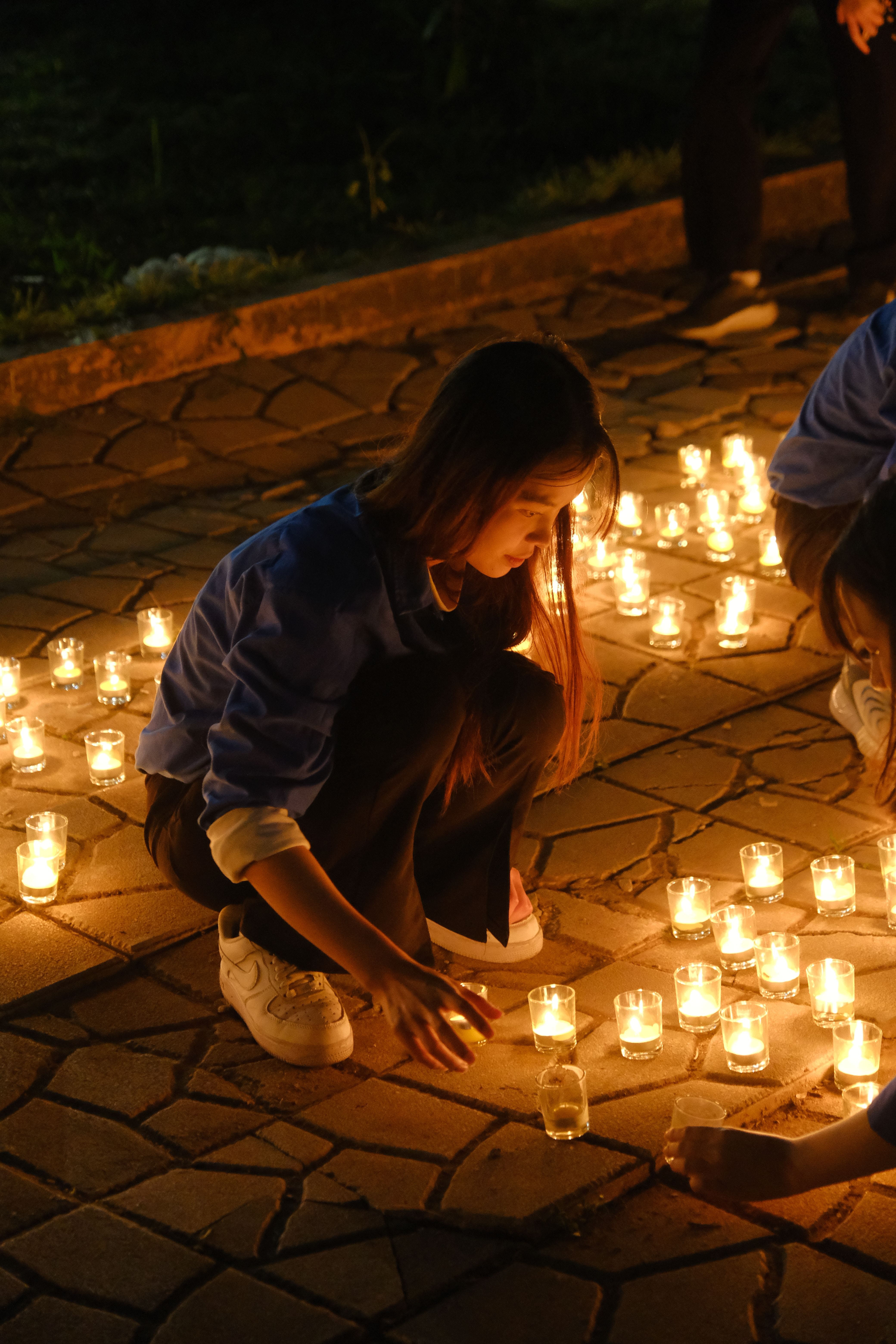 Serene Candlelight Vigil at Night Outdoors · Free Stock Photo