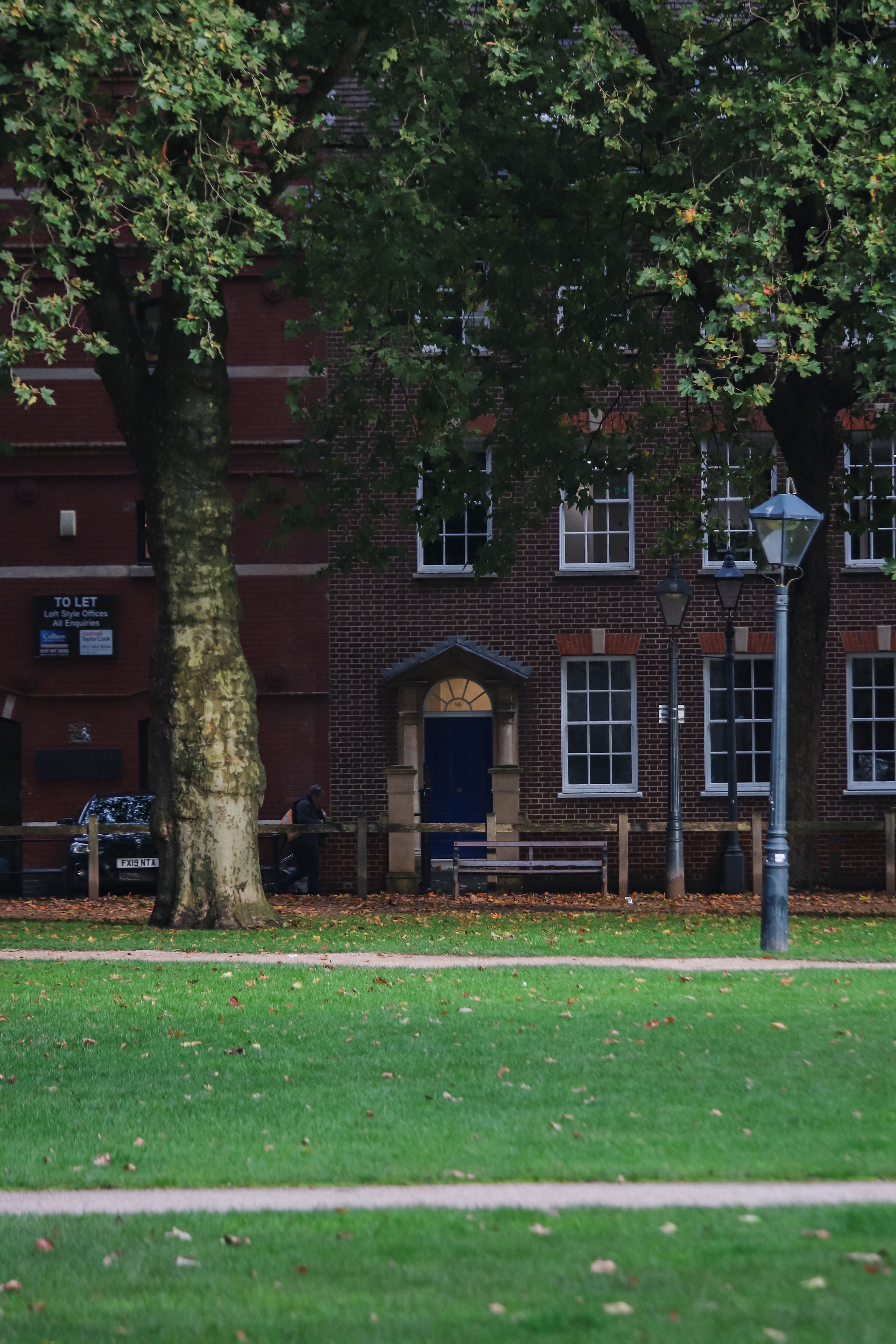 Historic Brick Building in Leafy Urban Park Setting · Free Stock Photo