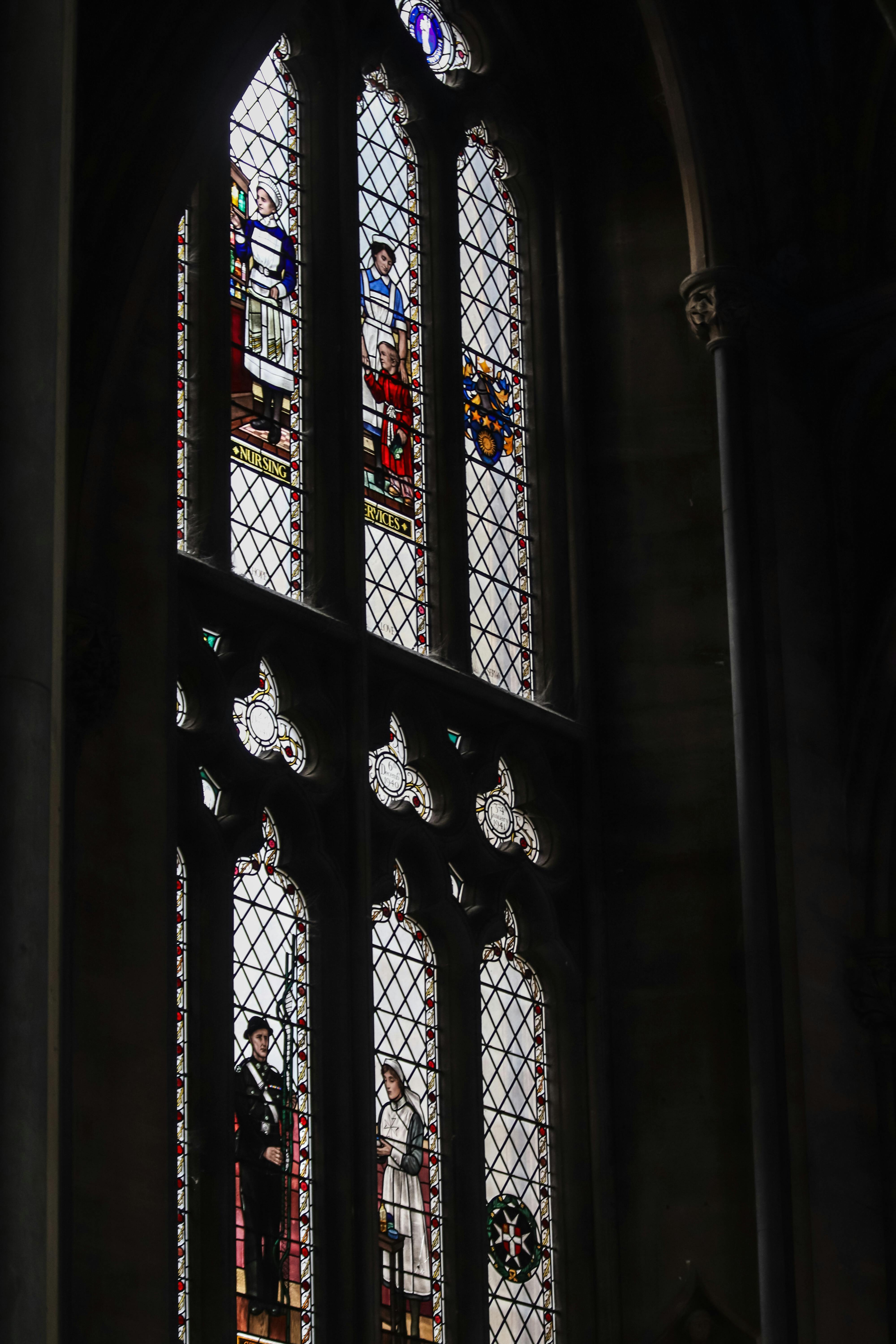 Gothic Stained Glass Window in Dimly Lit Church · Free Stock Photo