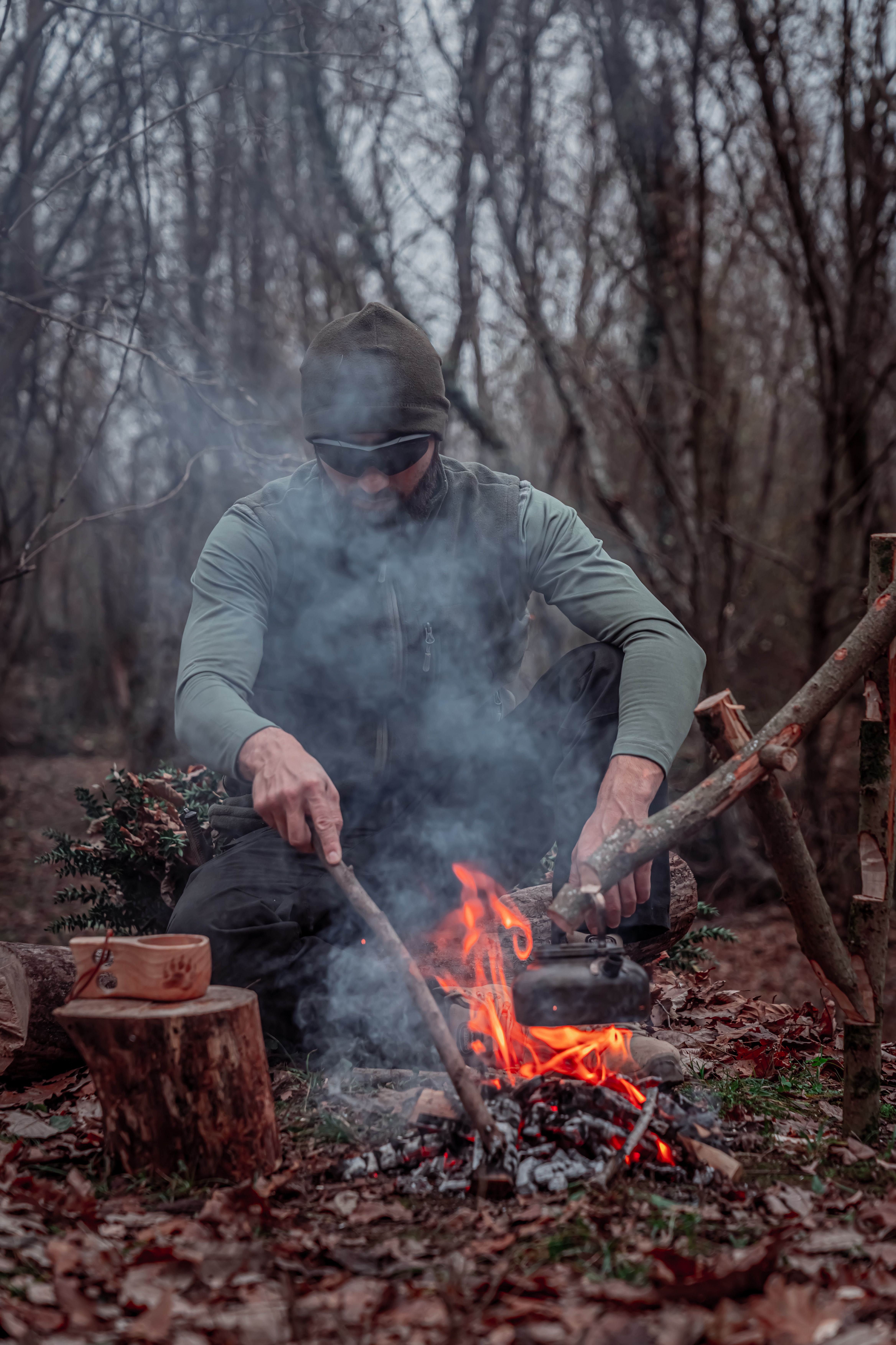Man Tending Campfire in Woodland Setting · Free Stock Photo