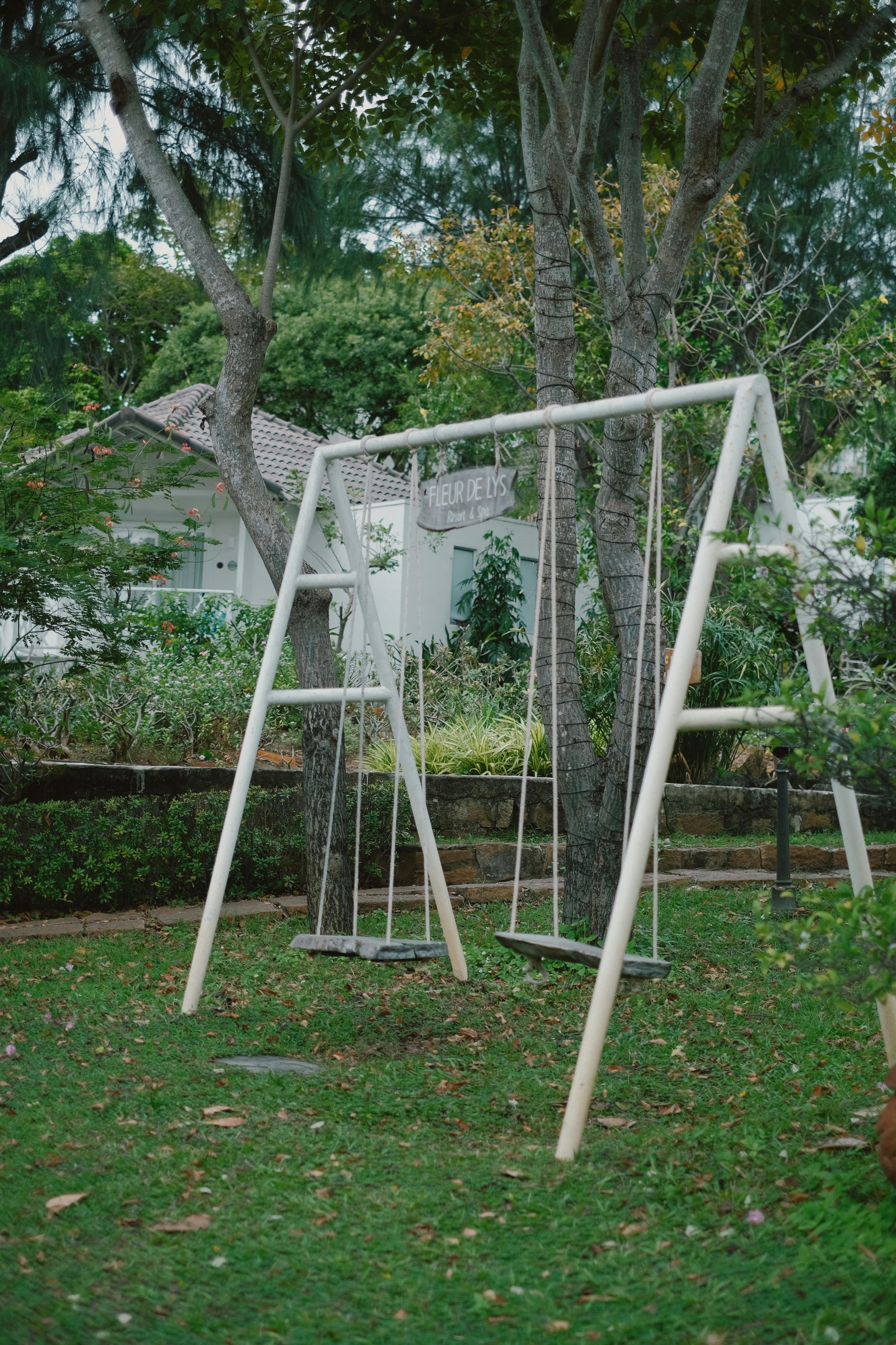 Rustic Swing Set in Lush Green Garden · Free Stock Photo