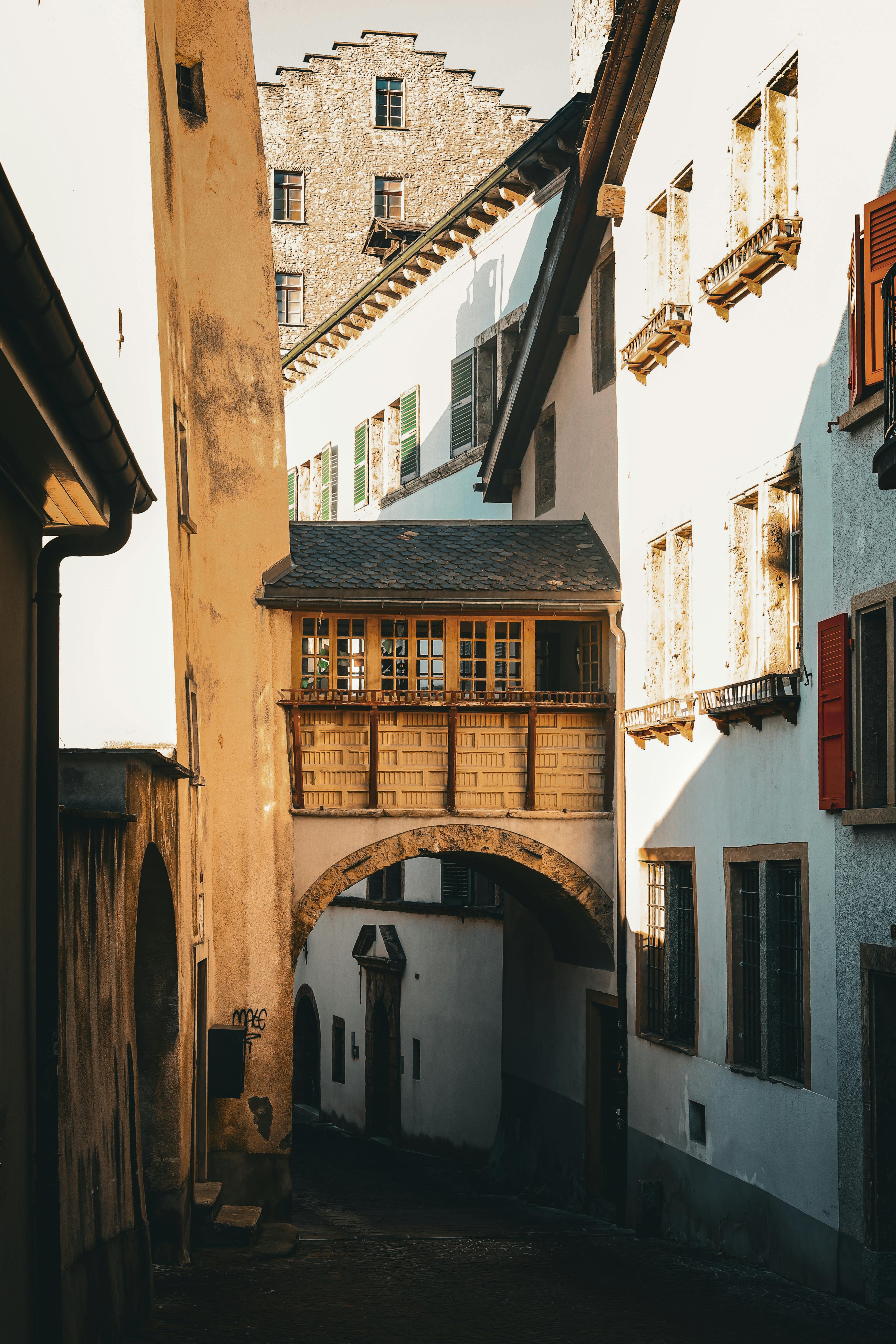 Charming Historic European Alleyway with Arch Bridge · Free Stock Photo
