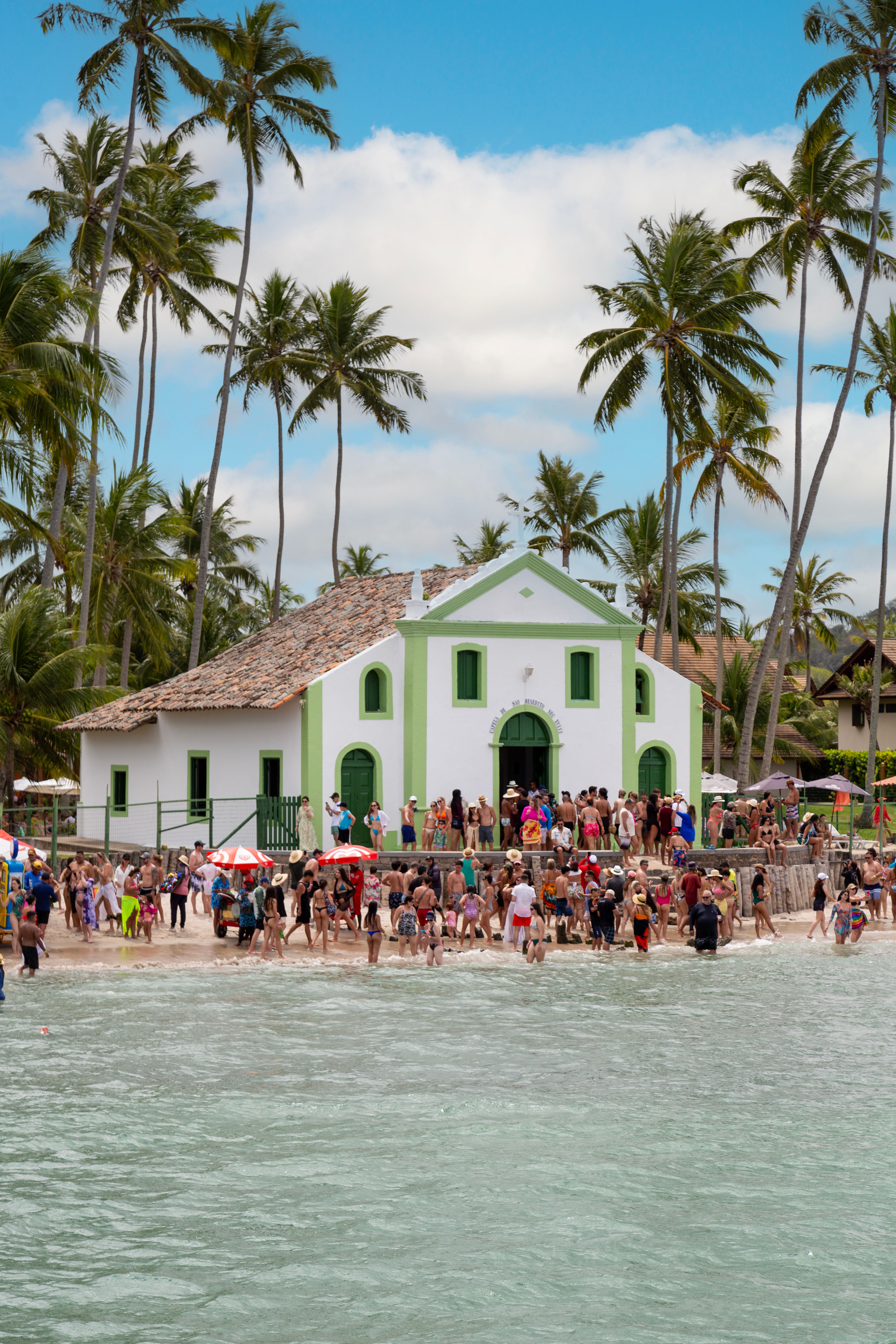 Busy Beach Scene by Historic Coastal Chapel · Free Stock Photo