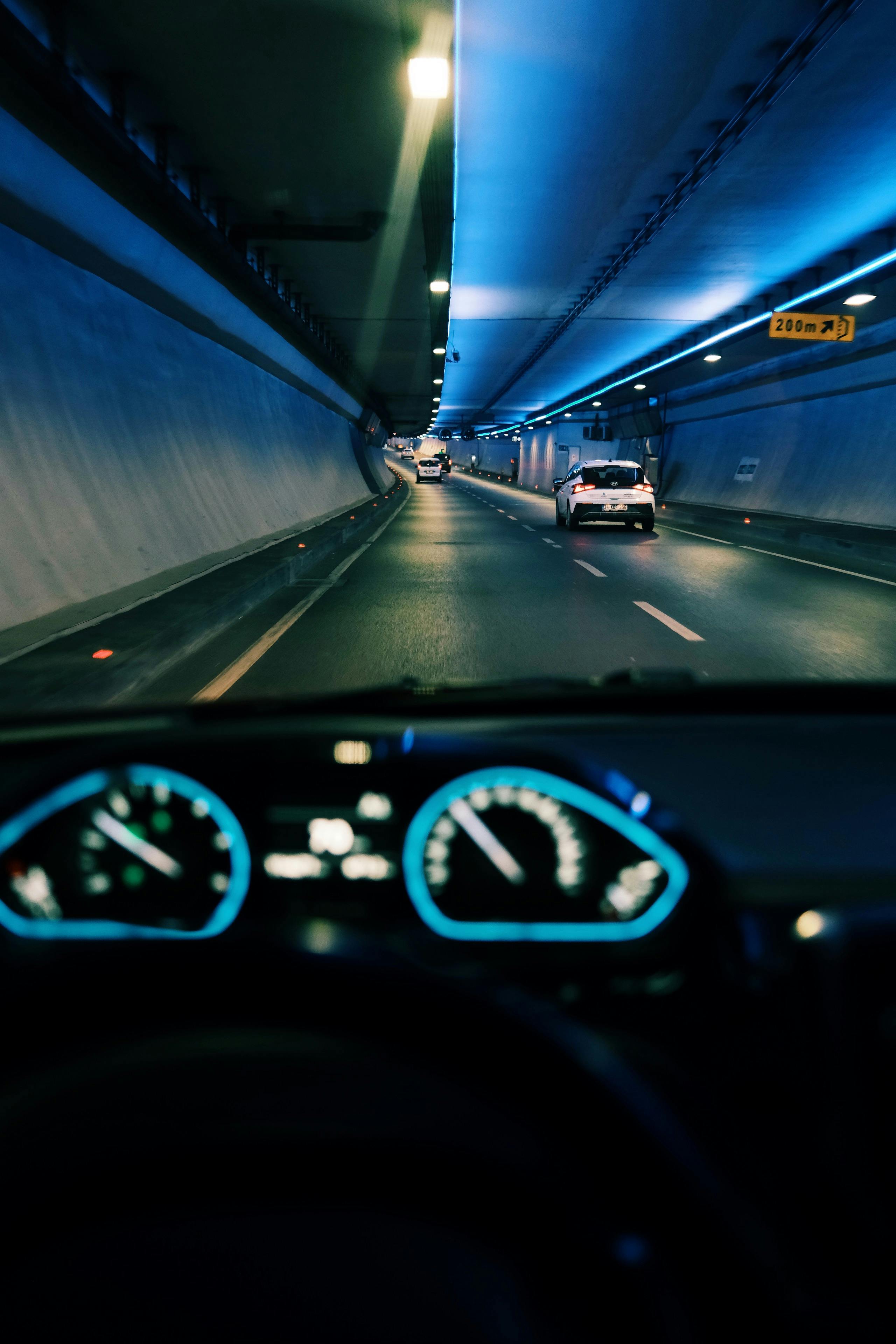 Driving Through Illuminated Tunnel at Night · Free Stock Photo