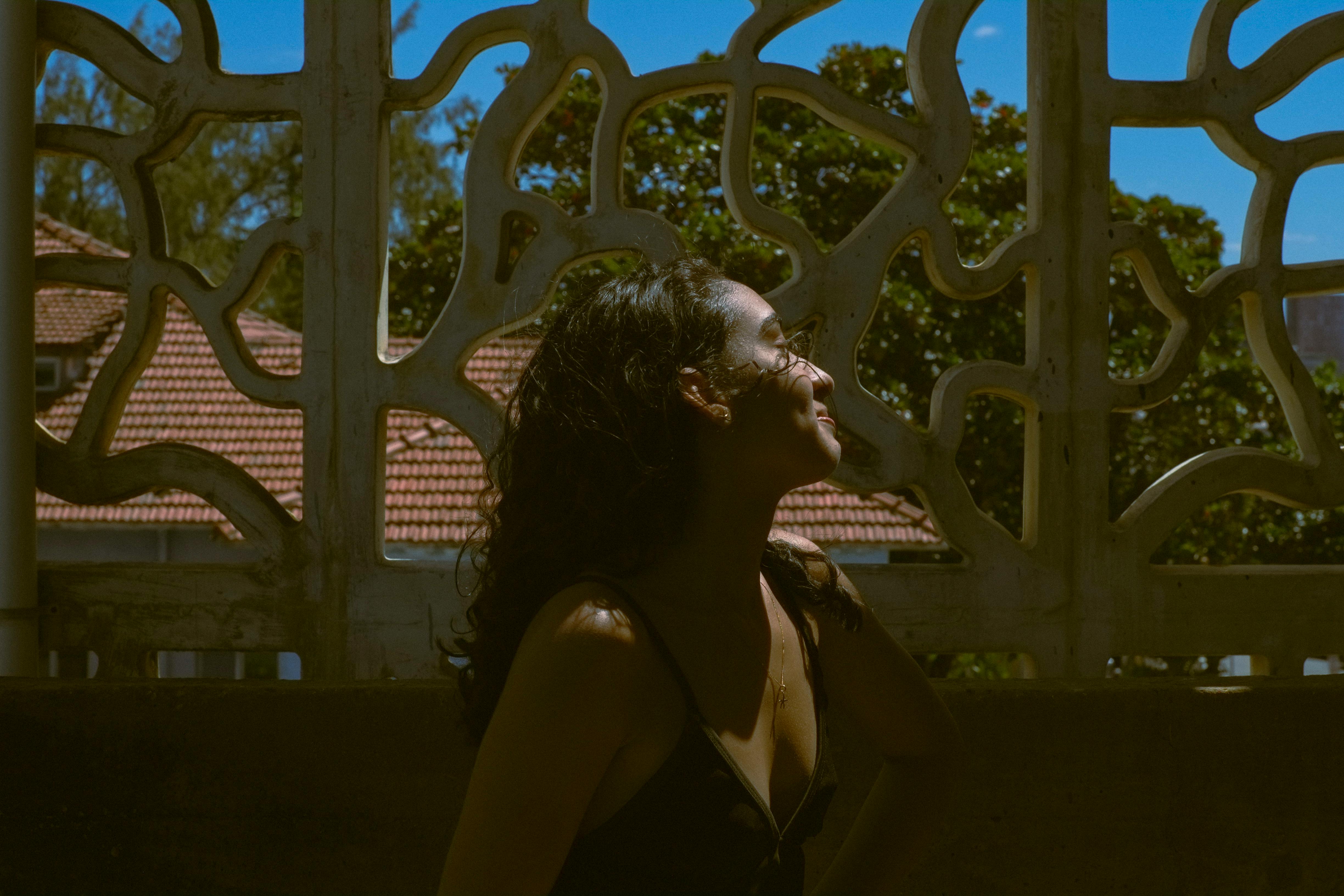 Sunlit Portrait of Woman in Unique Architectural Setting · Free Stock Photo