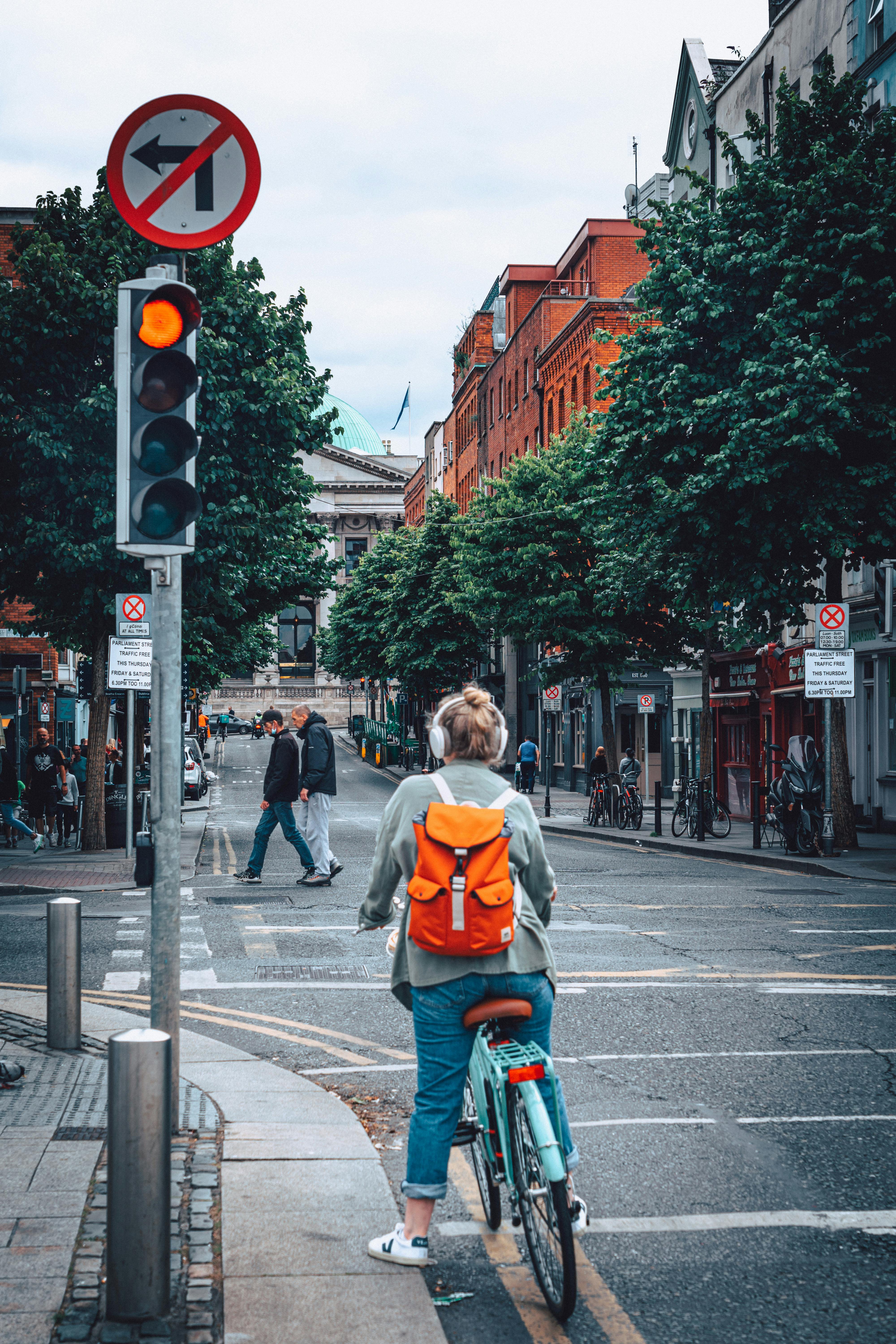 Urban Cyclist Waiting at Traffic Light in City · Free Stock Photo