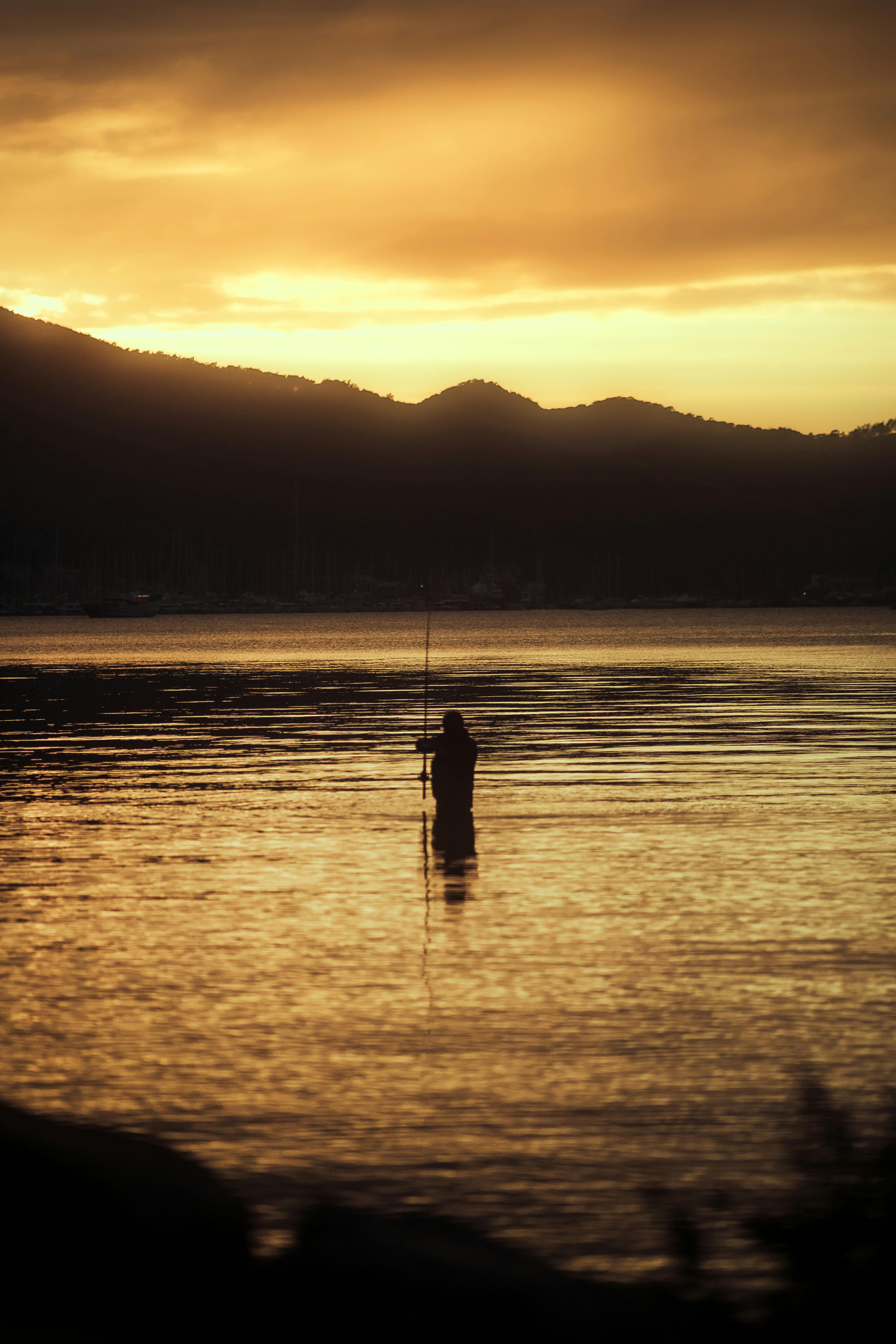 Silueta De Una Persona Pescando Al Atardecer Junto Al Lago · Foto de ...