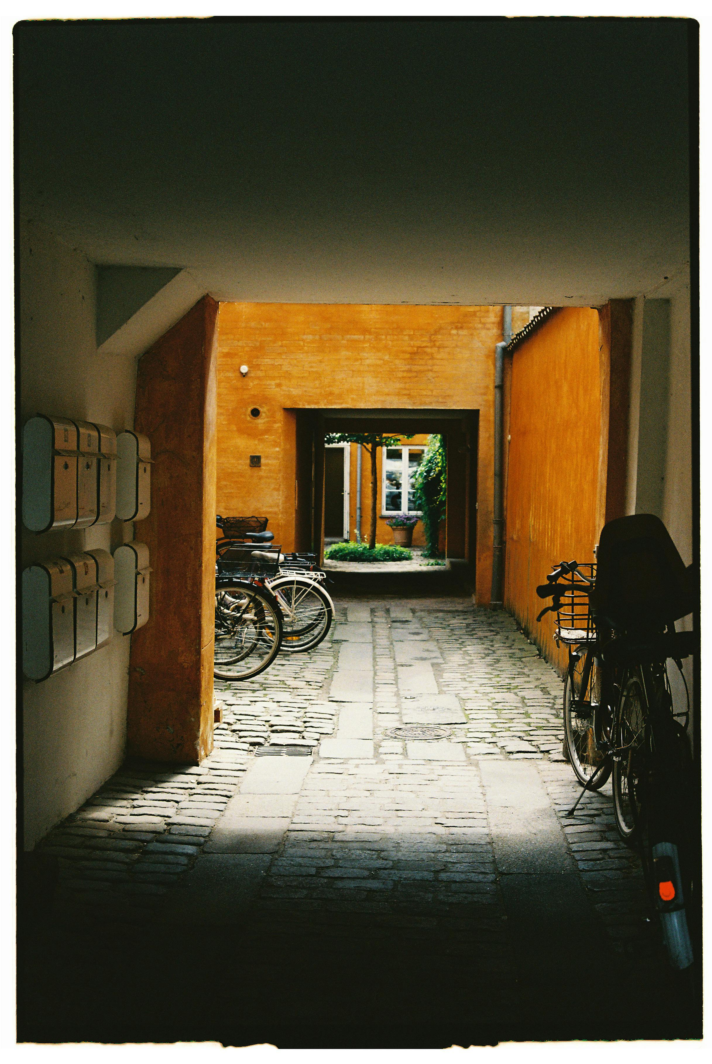 Charming Bicycle Alley with Yellow Walls · Free Stock Photo