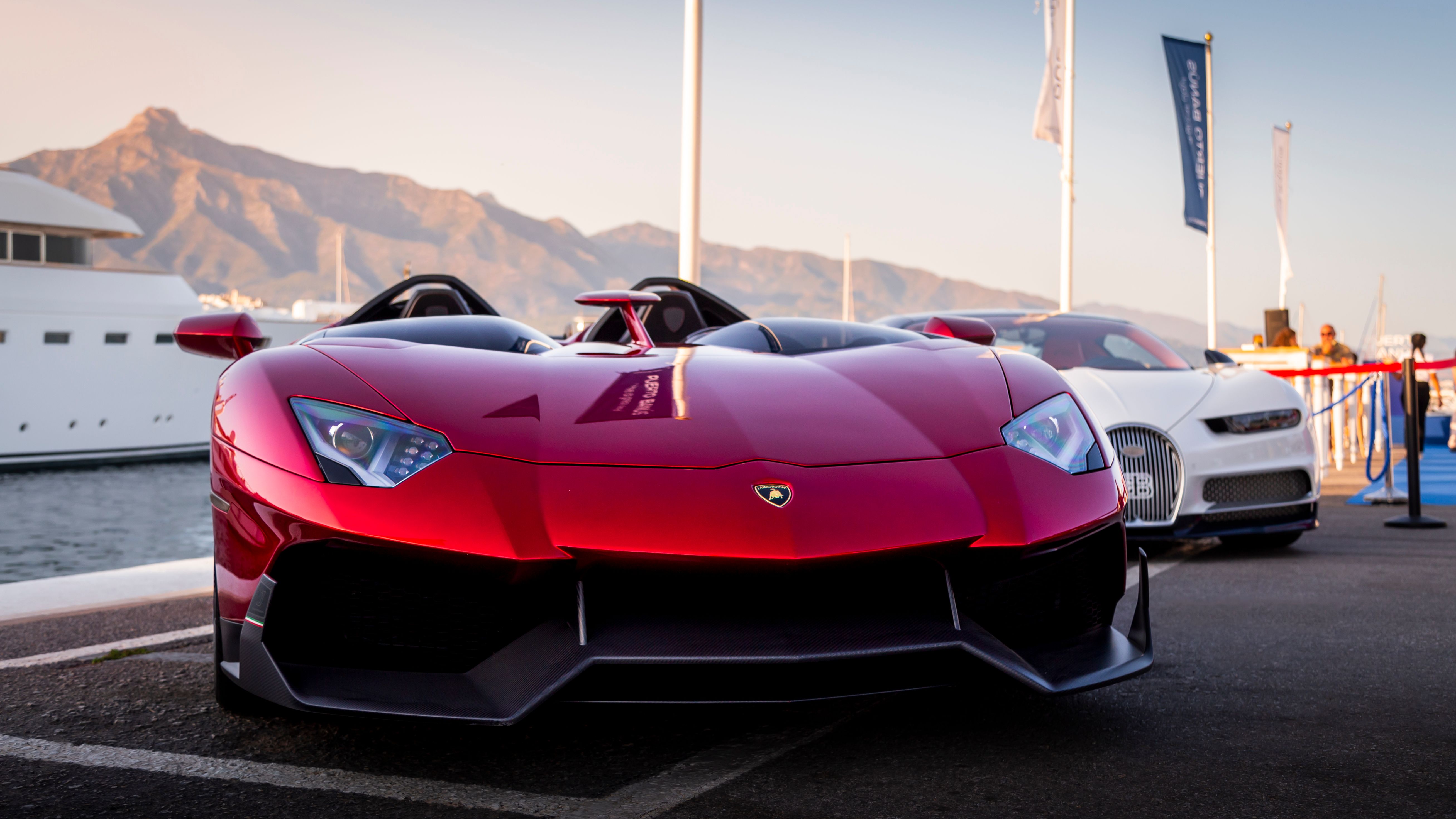Stunning Red Supercar at Marina with Mountain View · Free Stock Photo