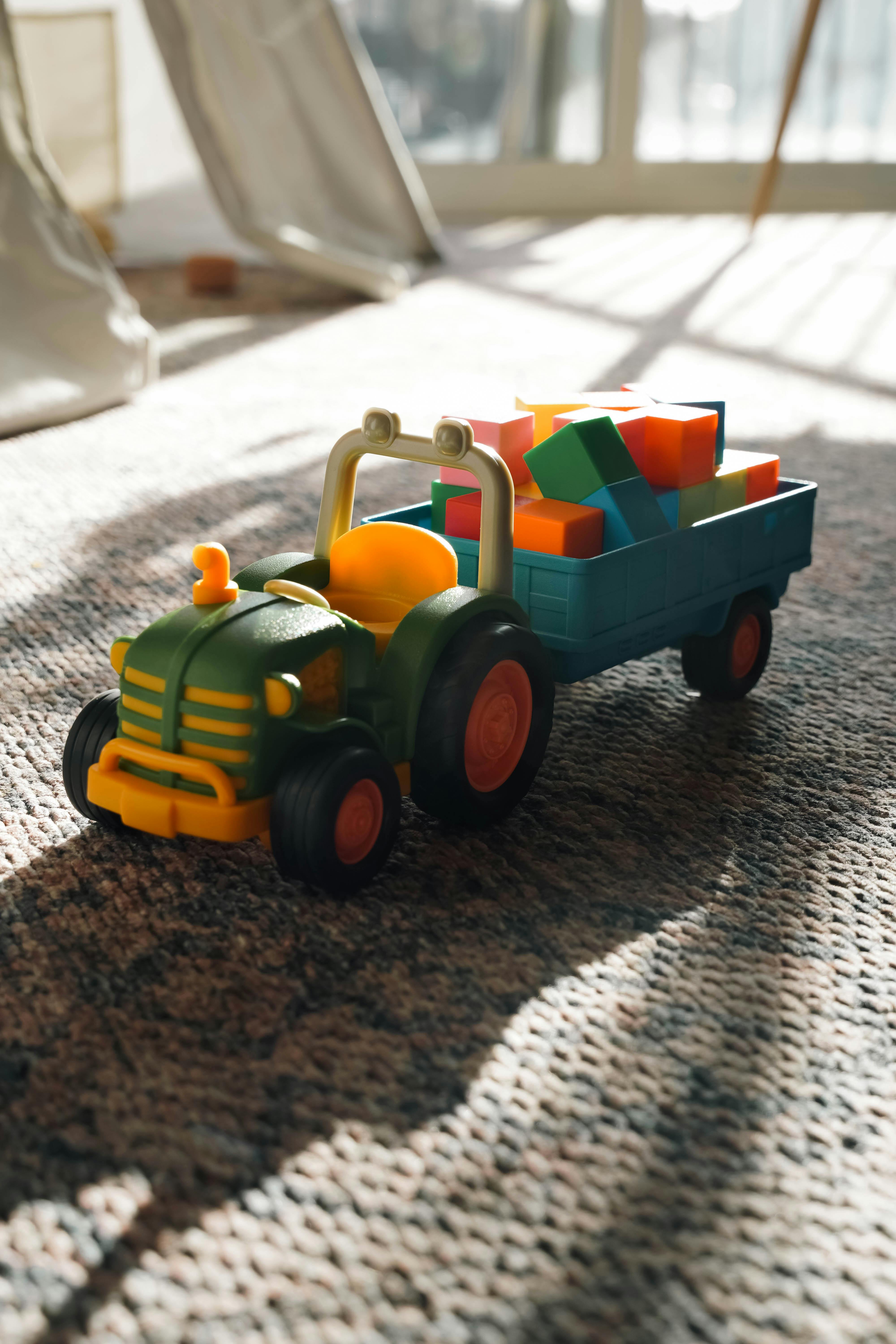 Colorful Toy Tractor on Carpet in Sunlit Room · Free Stock Photo