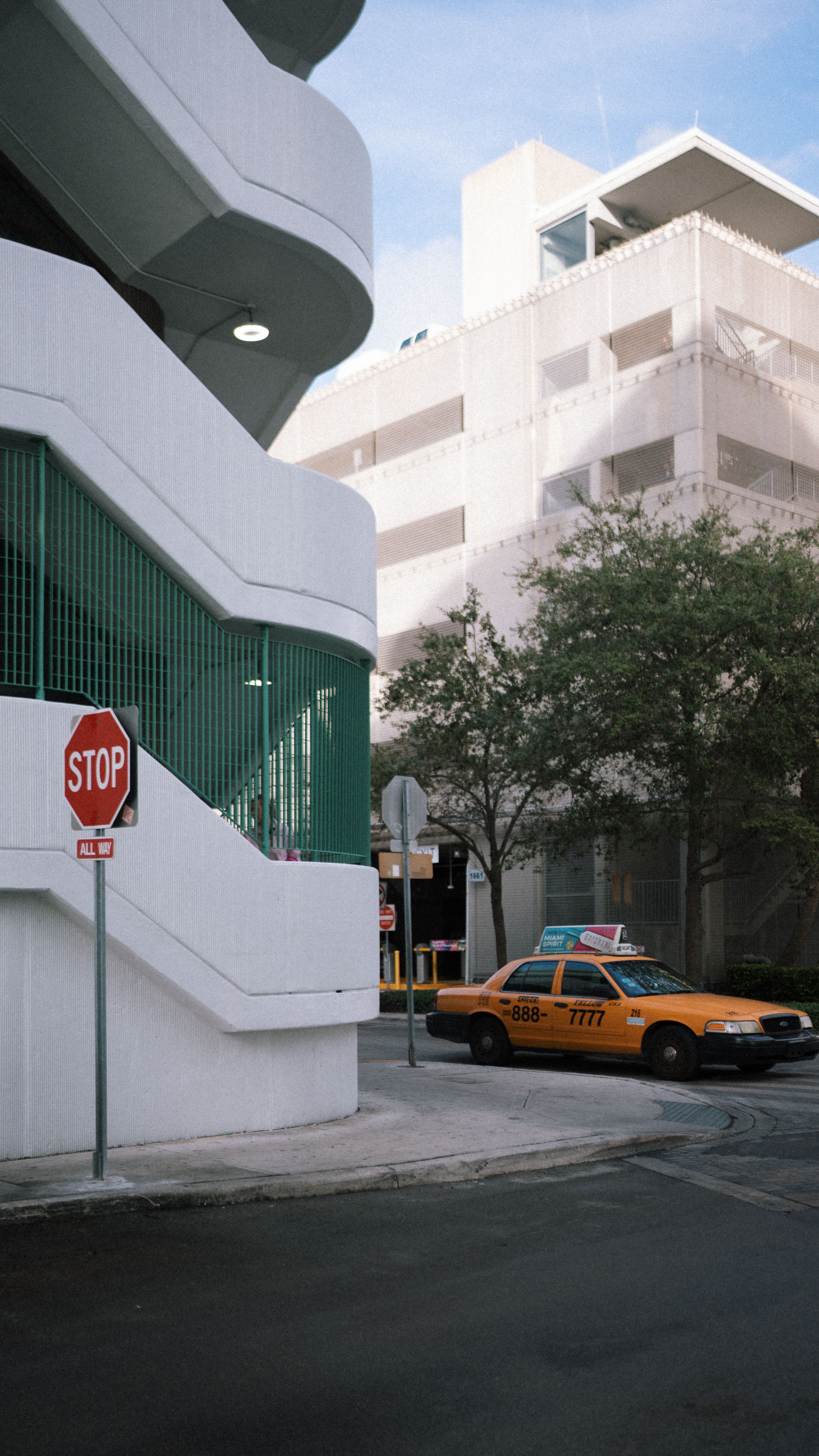 Urban Scene with Yellow Taxi and Stop Sign · Free Stock Photo