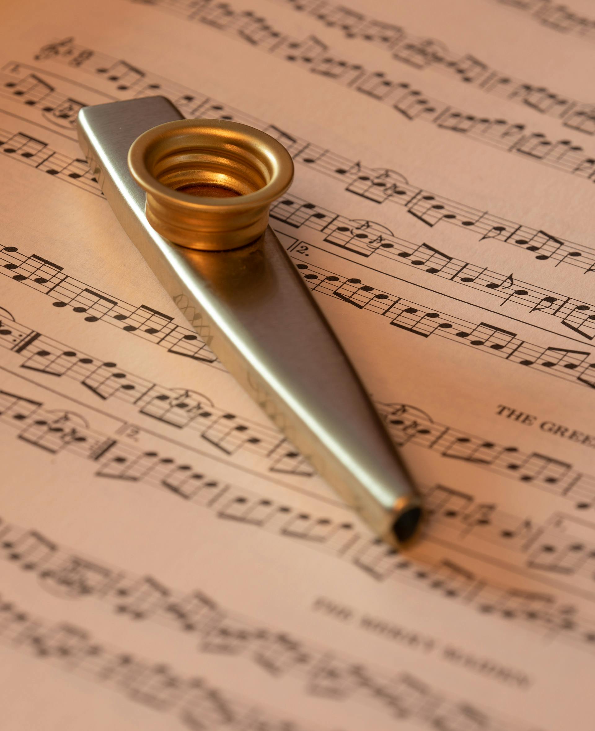Elegant Brass Kazoo on Sheet Music · Free Stock Photo