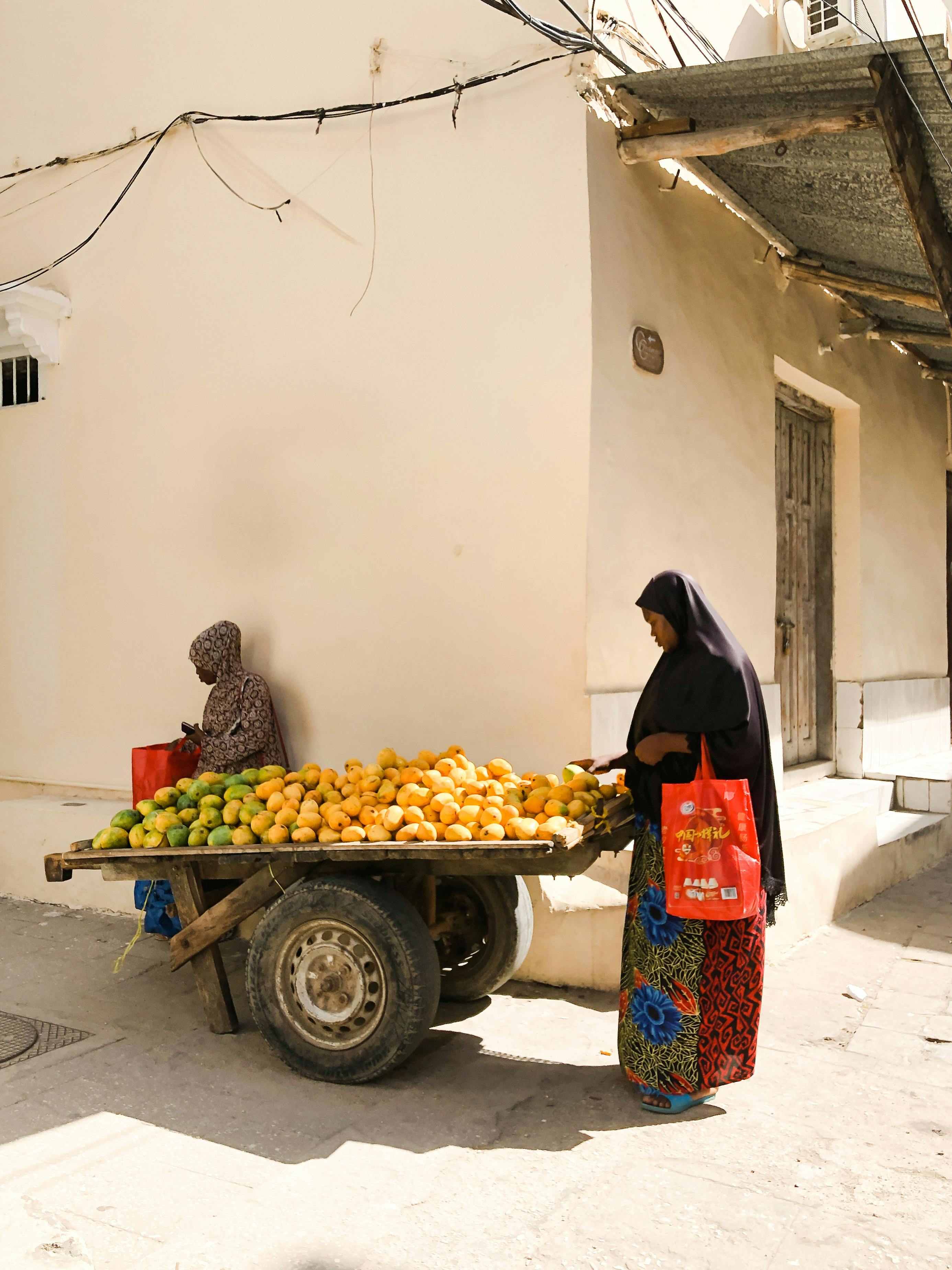 Street Market with Mango Vendor in Zanzibar · Free Stock Photo
