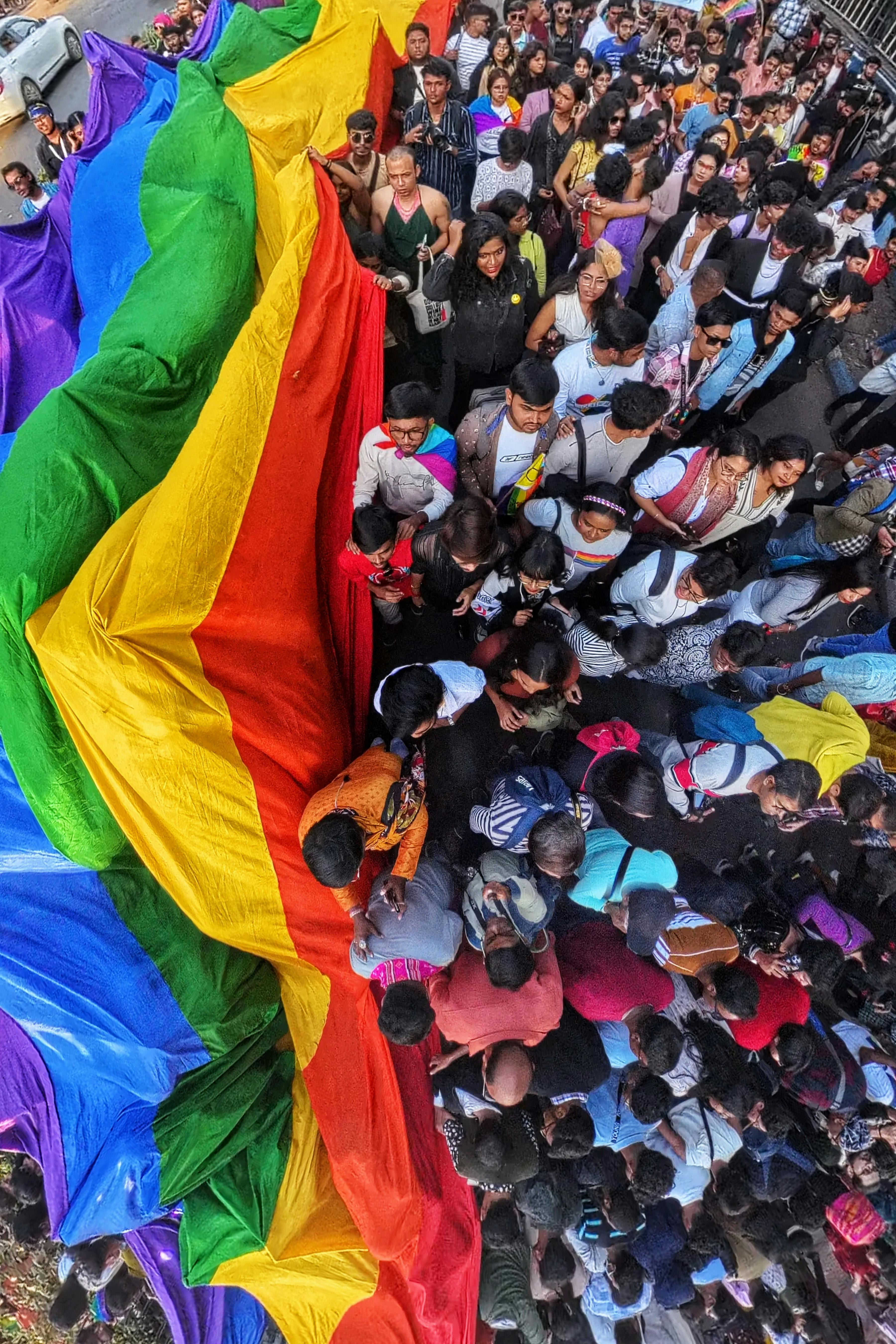 LGBTQ Pride Parade Crowd with Rainbow Flag · Free Stock Photo
