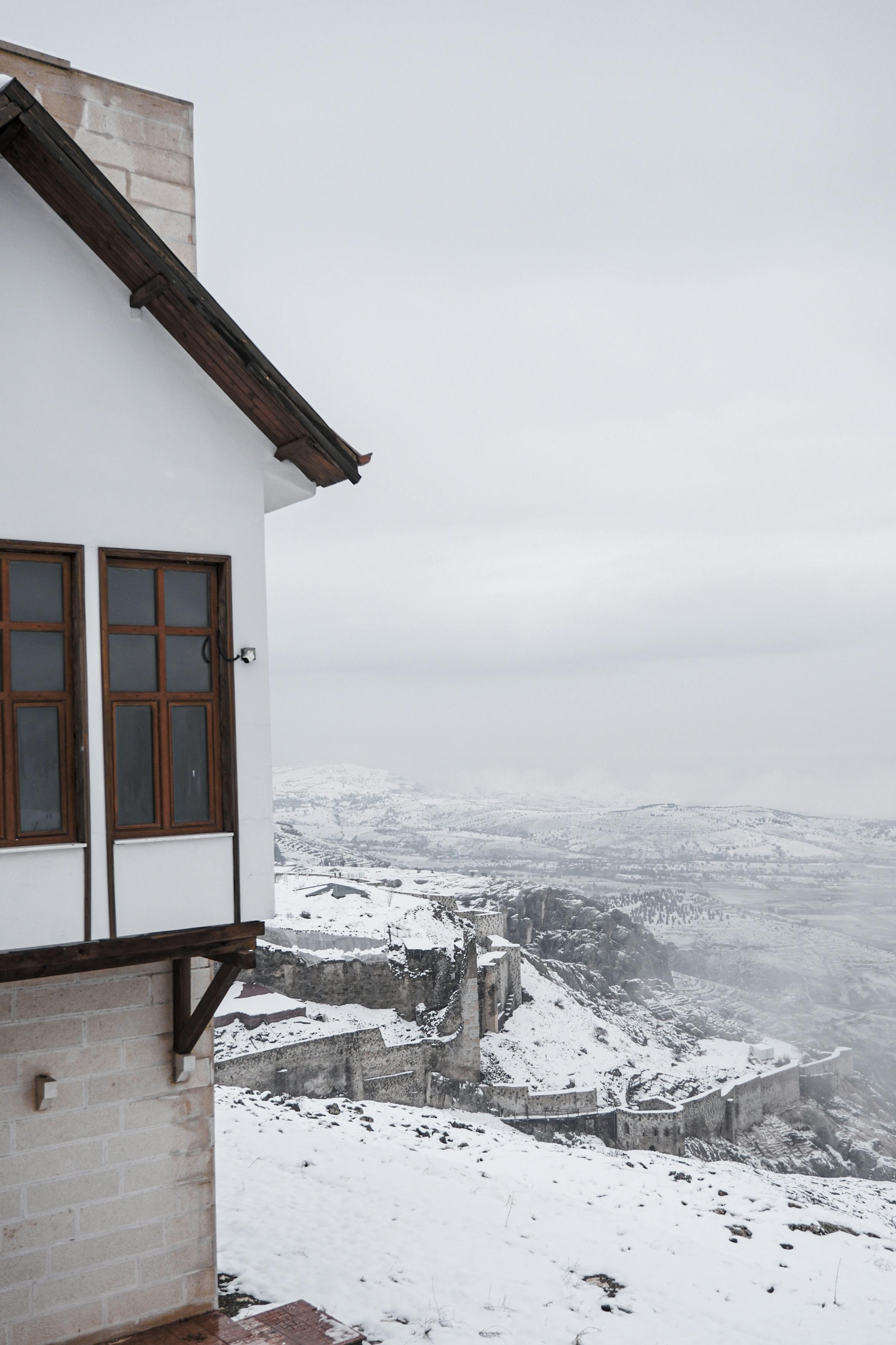 Snowy Landscape with House on Cliff Edge · Free Stock Photo