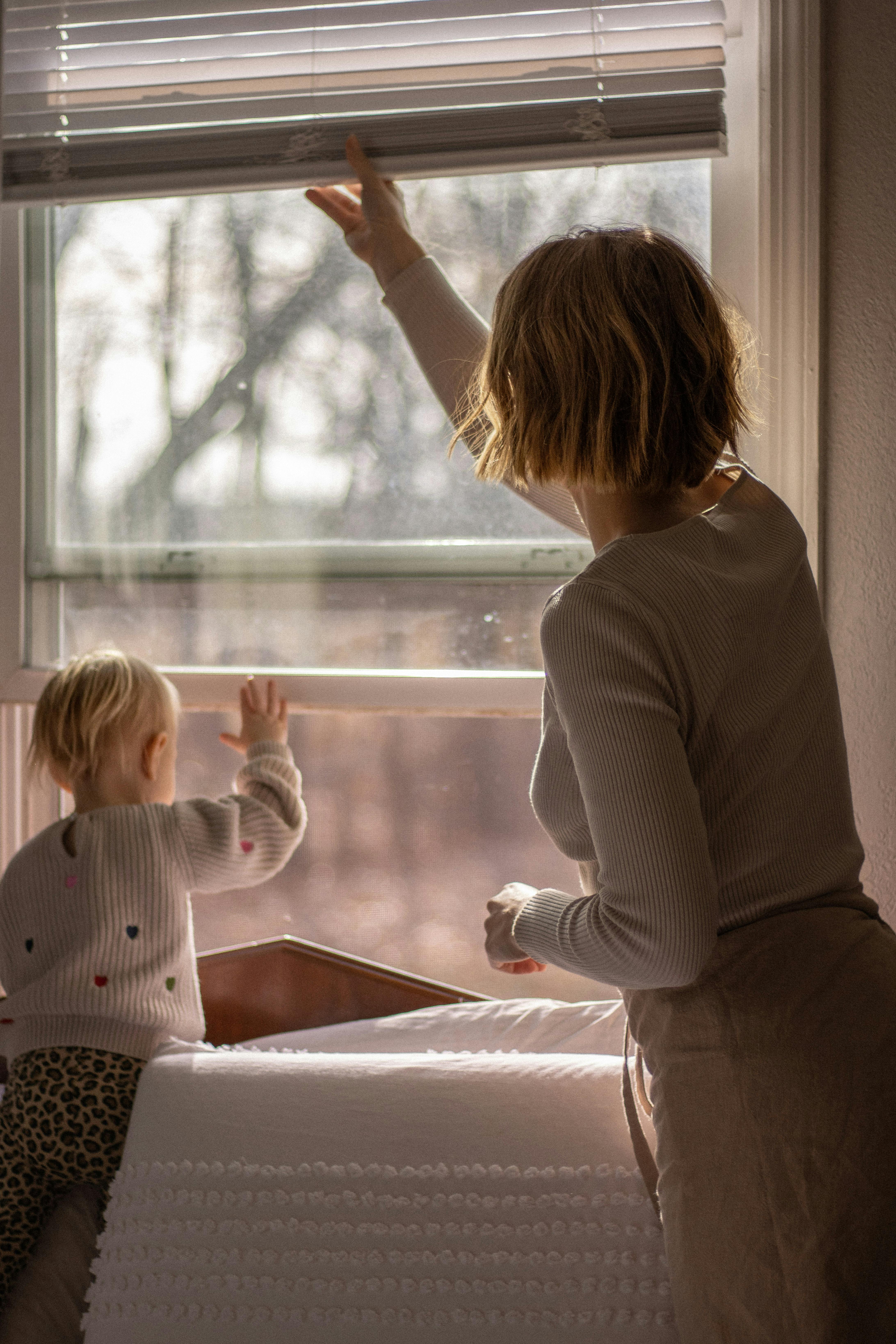 Mother and Child Enjoying Natural Light through Window · Free Stock Photo