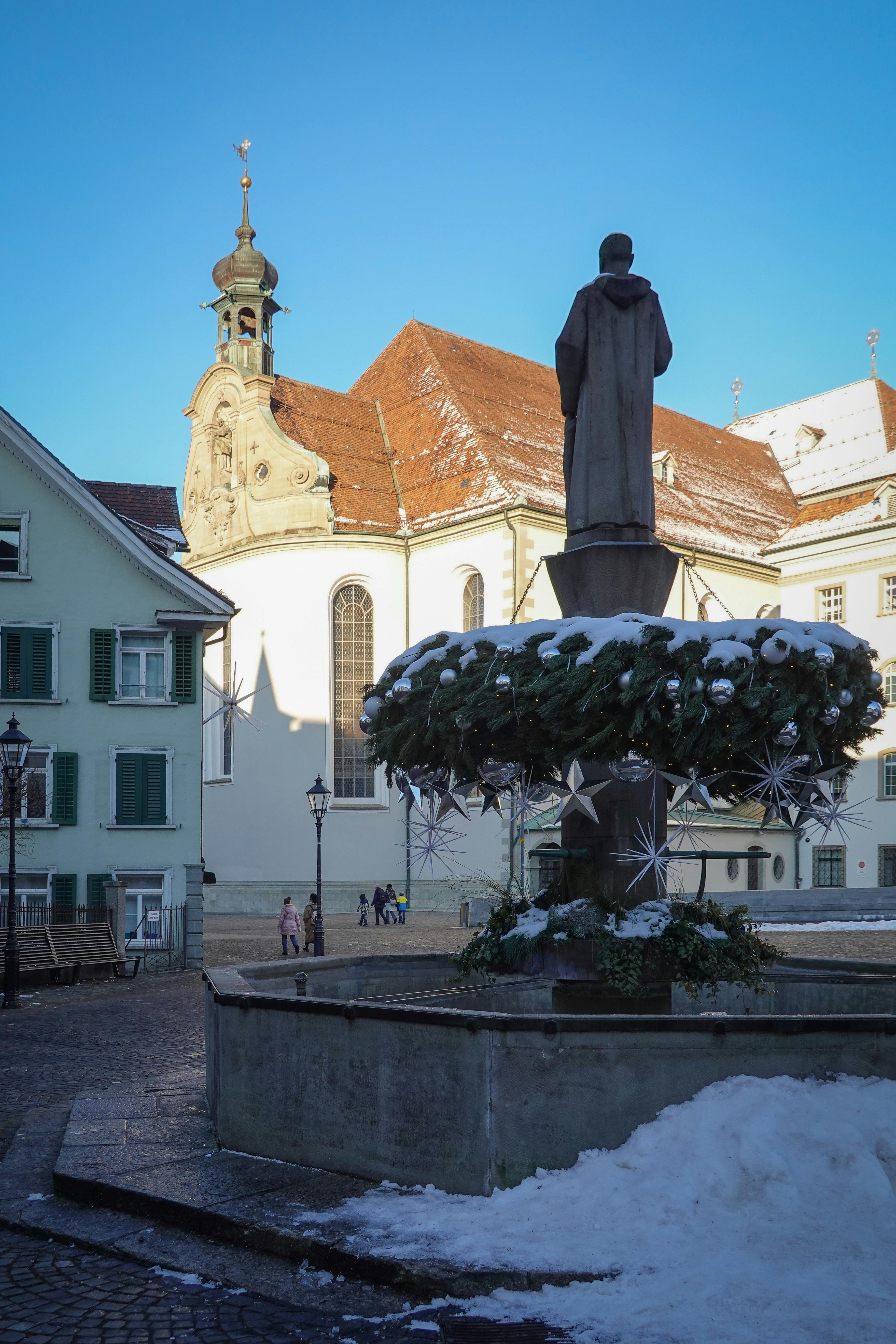 Historic Swiss Square with Snow-Covered Statue · Free Stock Photo