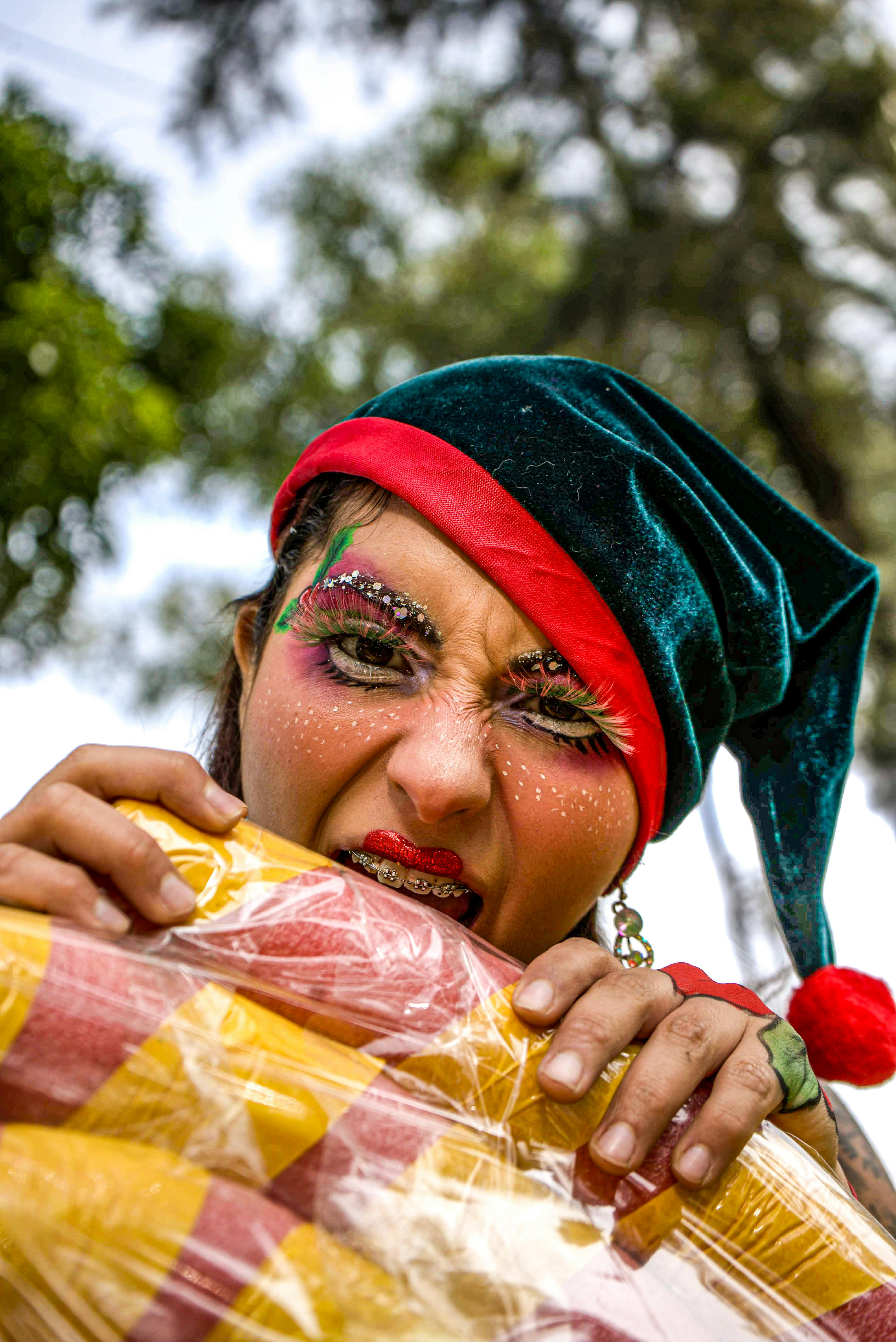 Playful Elf Biting Large Candy Outdoors · Free Stock Photo