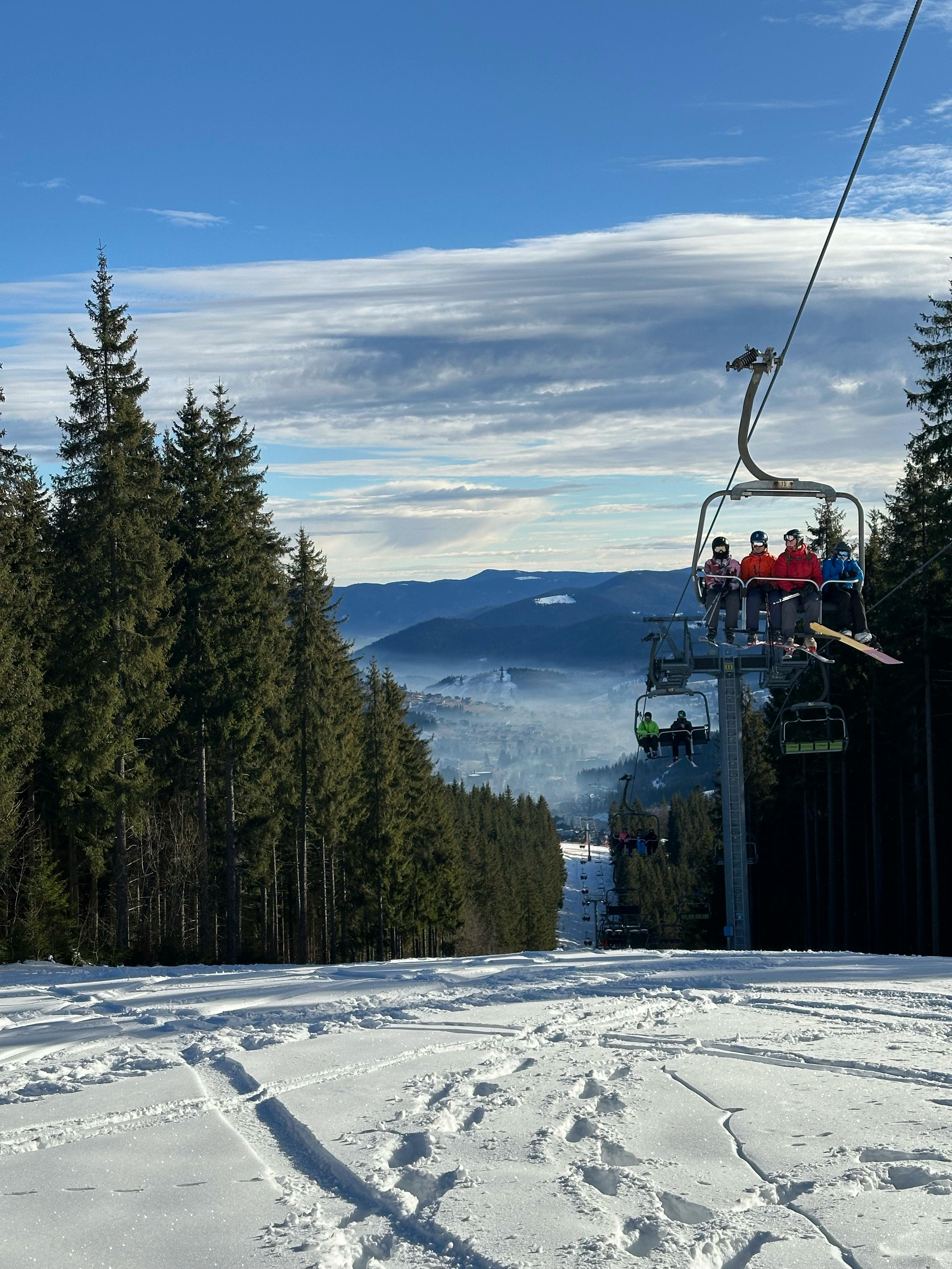 Skiers Enjoying a Scenic Mountain Chairlift Ride · Free Stock Photo