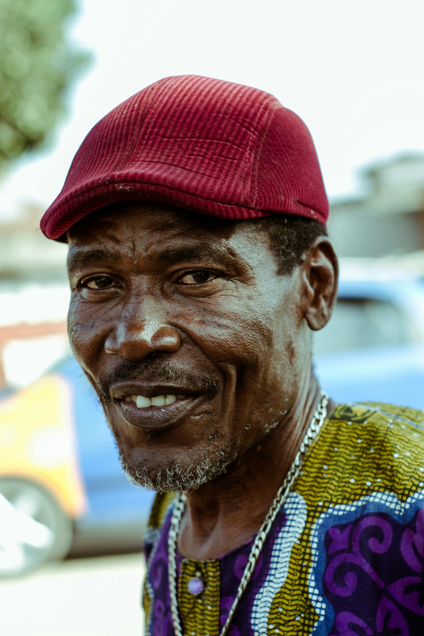 Portrait of a Man in Colorful Attire and Cap · Free Stock Photo