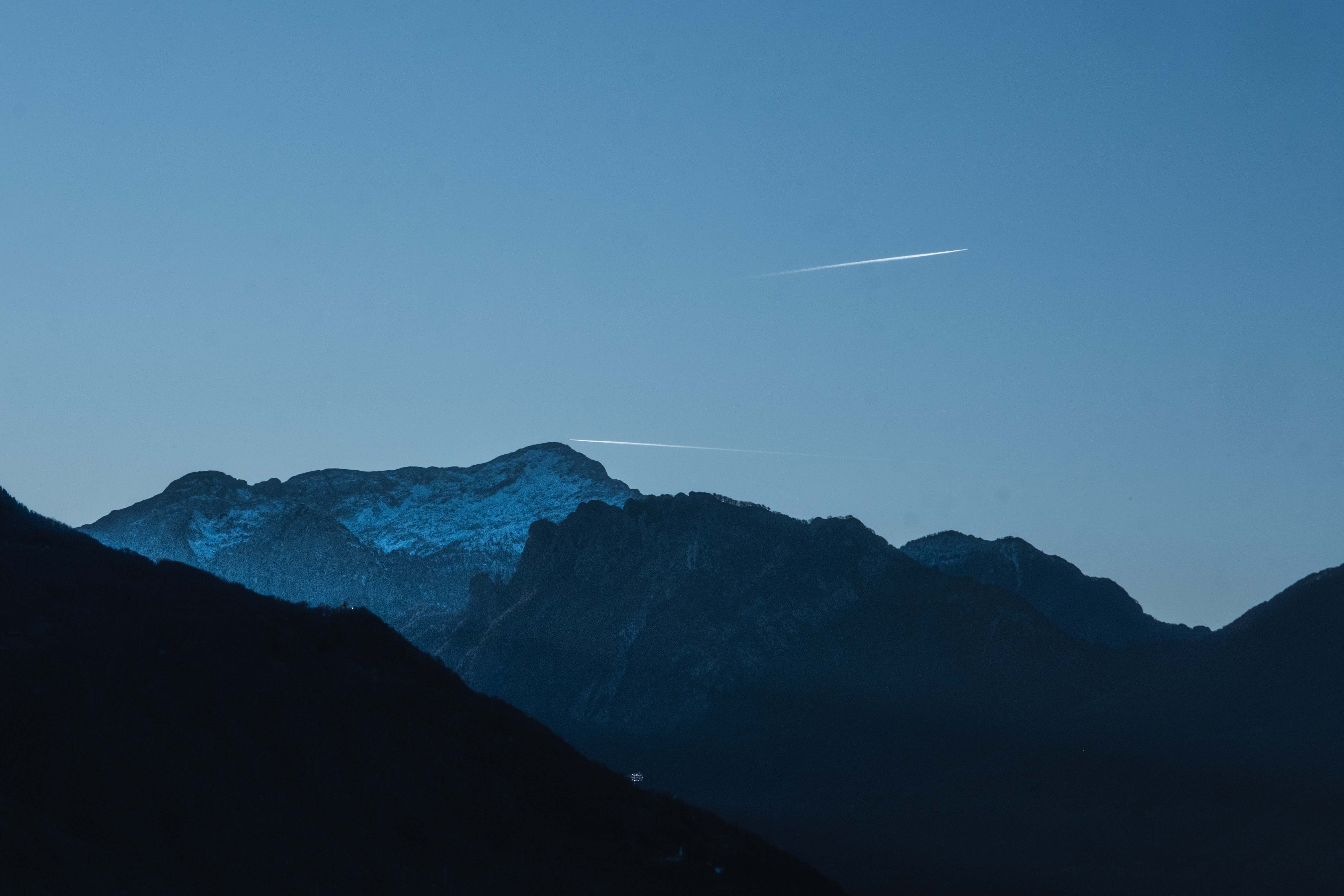 Stunning Twilight Mountain Landscape with Contrails · Free Stock Photo