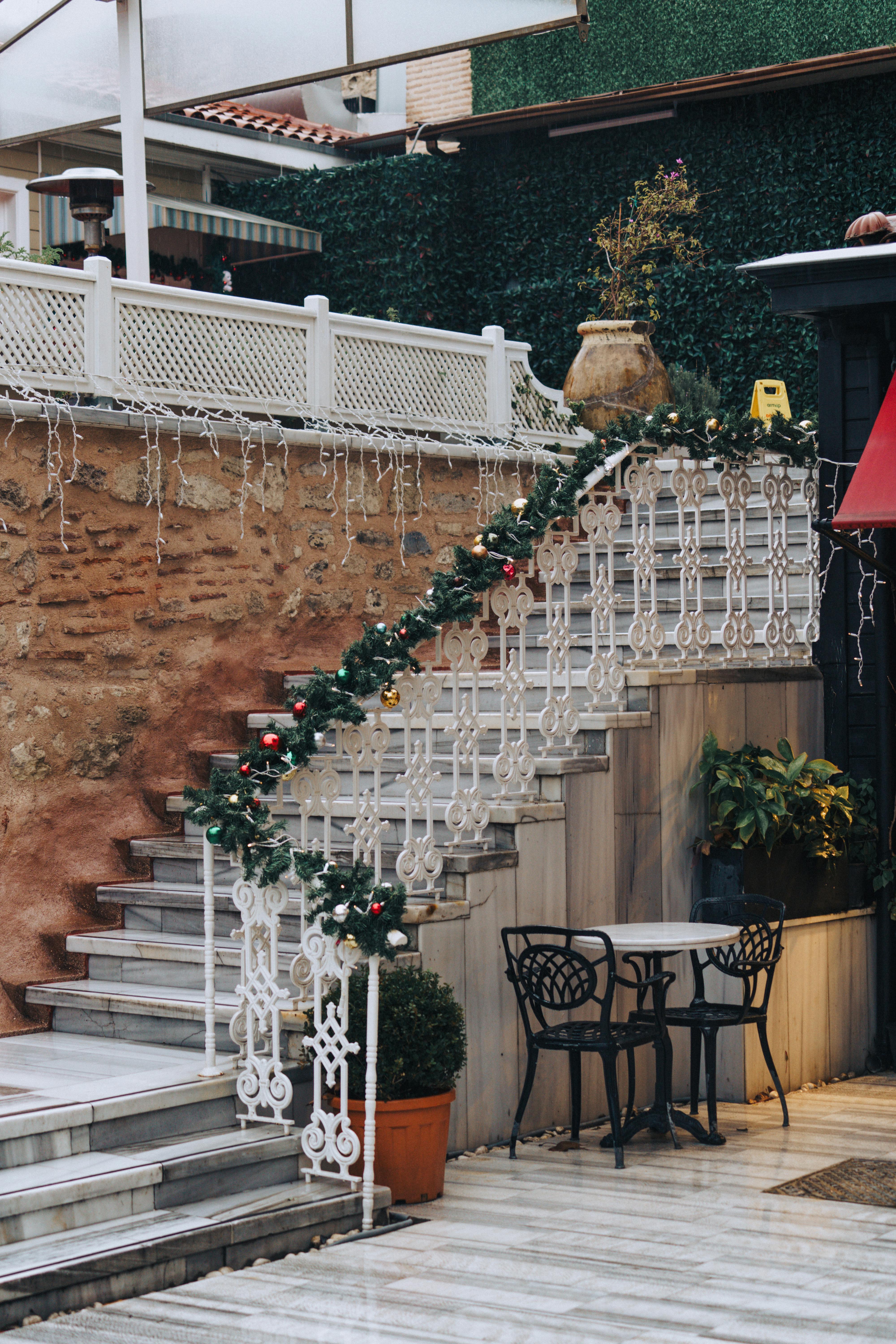 Charming Outdoor Cafe with Decorated Staircase · Free Stock Photo