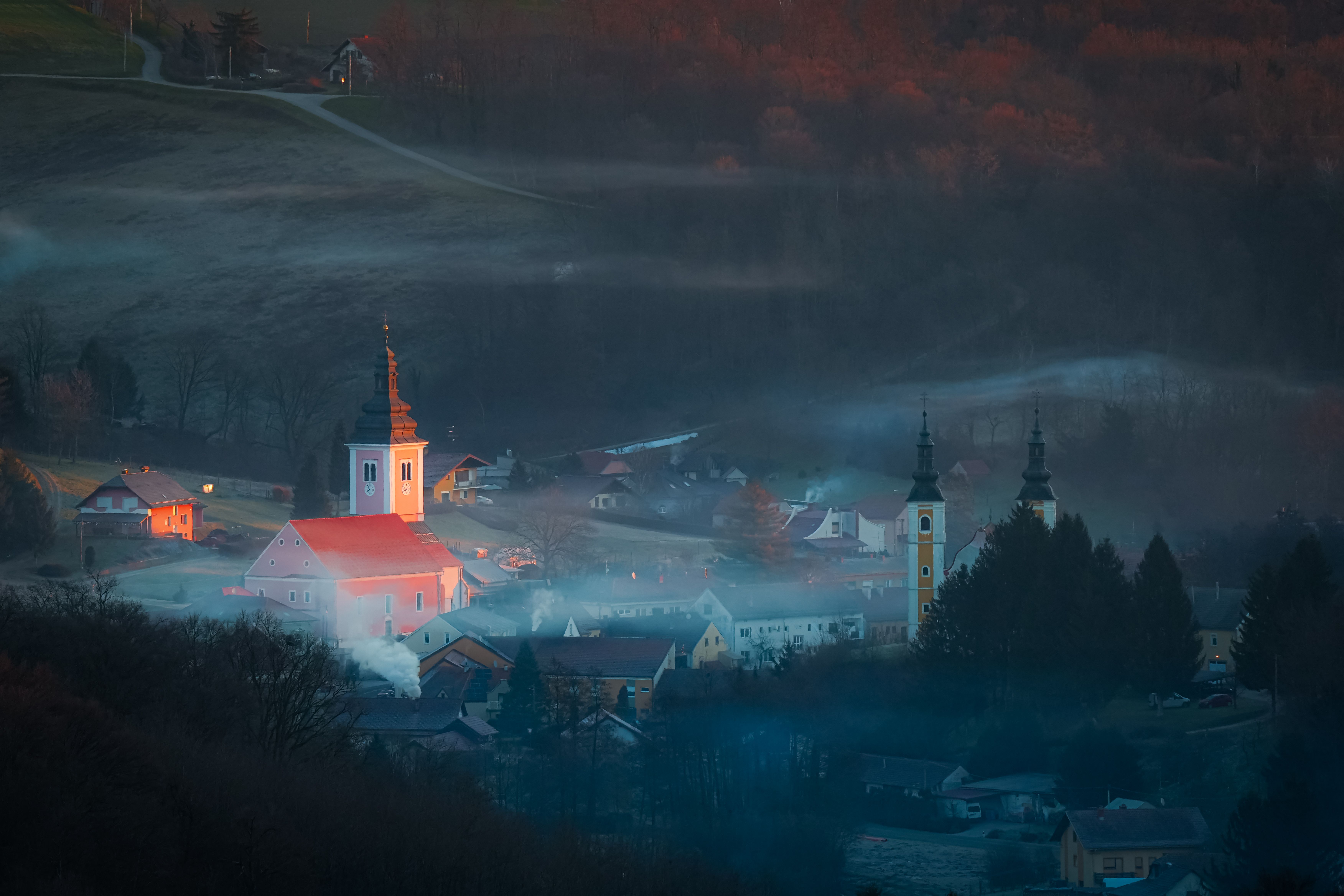 Charming Misty Village at Dusk with Church Towers · Free Stock Photo
