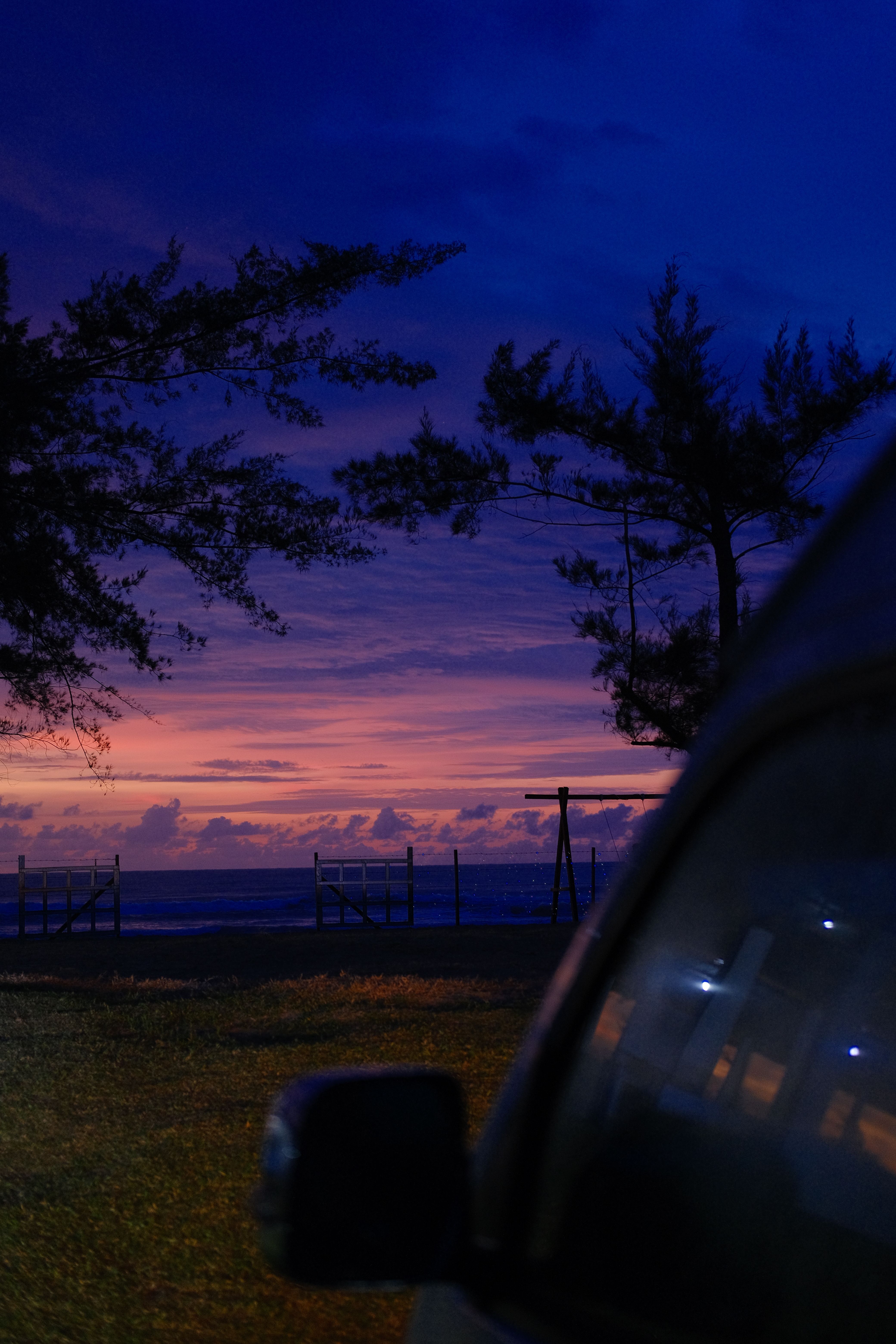Serene Twilight Beach Scene with Car Silhouette · Free Stock Photo