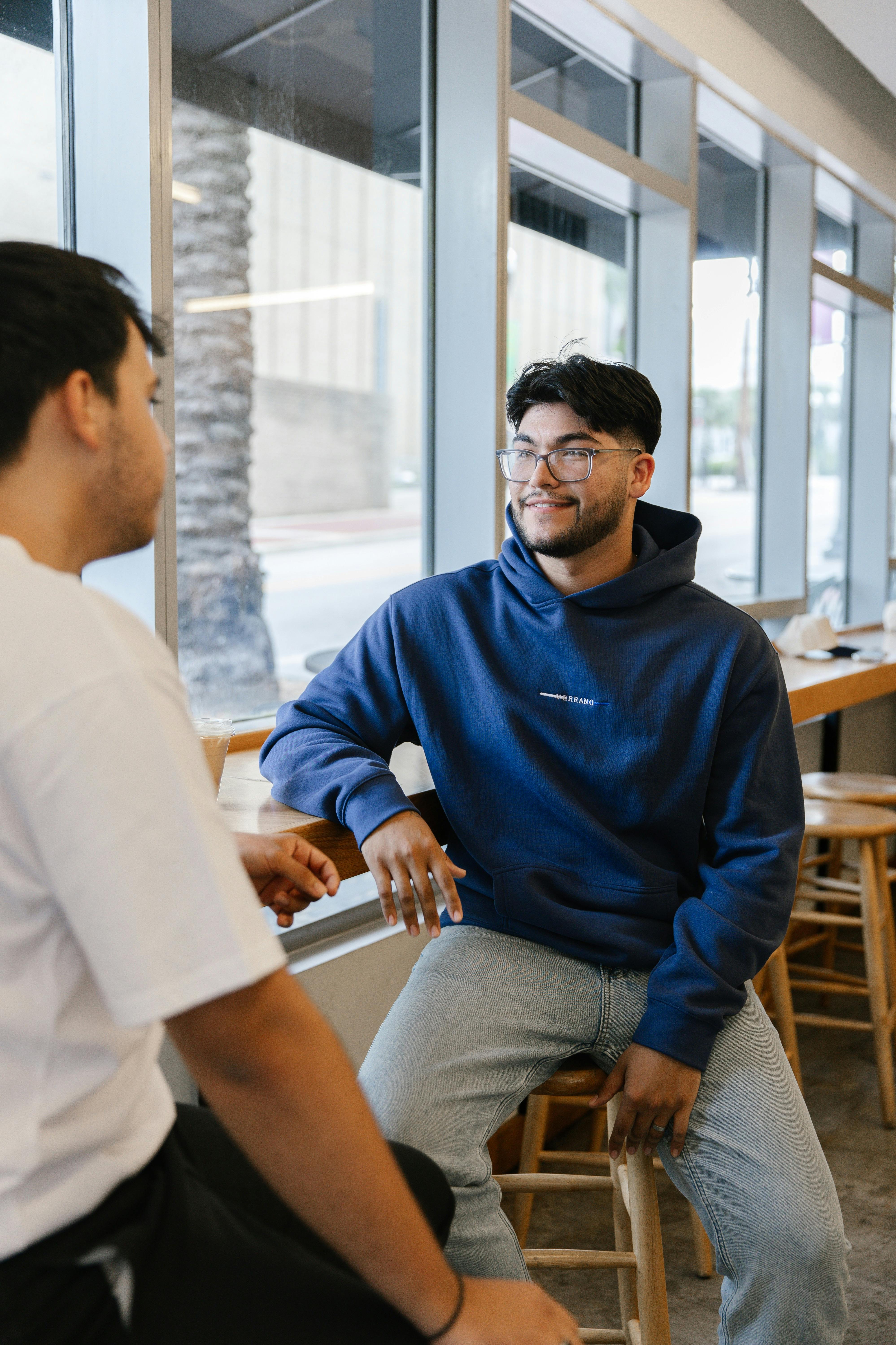 Casual Conversation Between Friends in Cafe · Free Stock Photo
