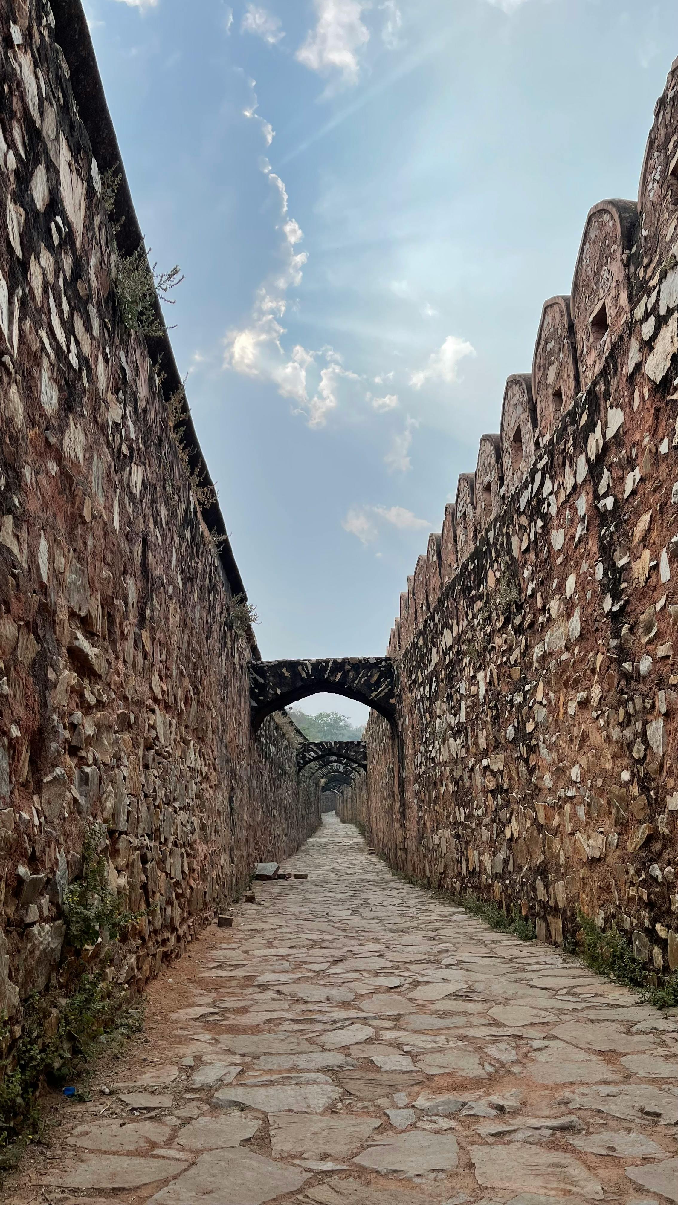 Historic Stone Corridor Under Blue Sky · Free Stock Photo