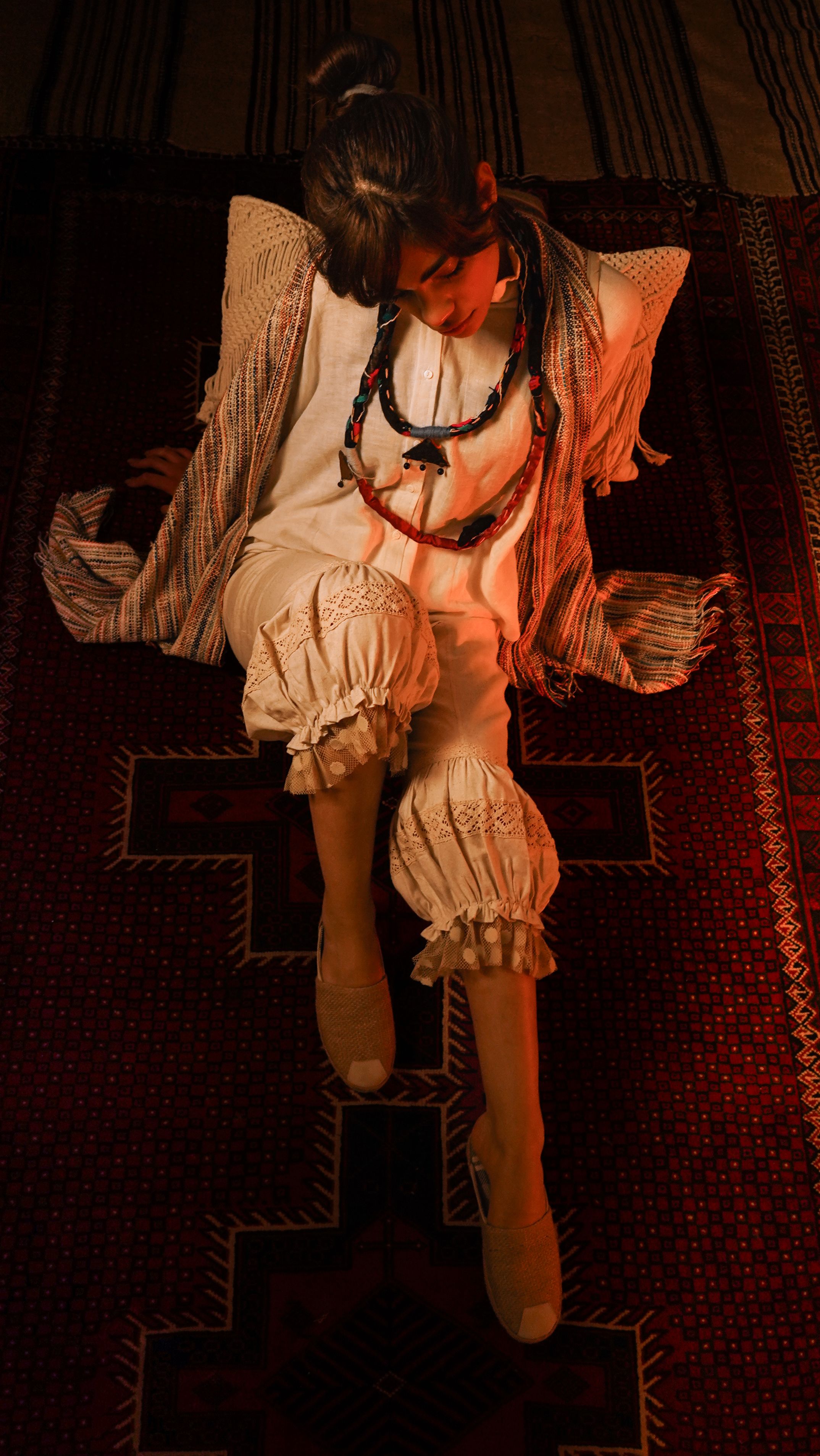 Fashionable Woman Sitting on Ornate Rug · Free Stock Photo