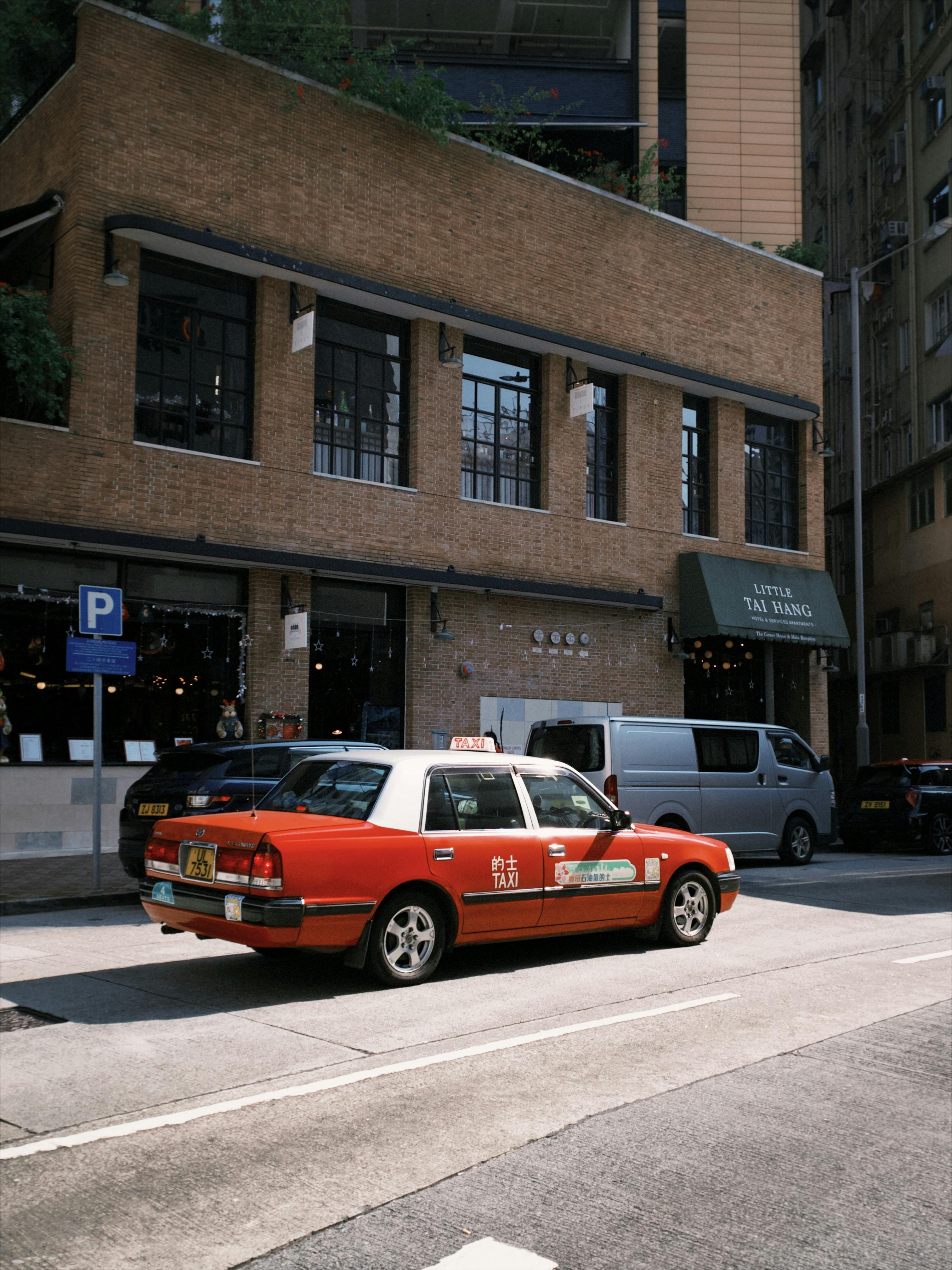 Classic Hong Kong Red Taxi in Urban Setting · Free Stock Photo