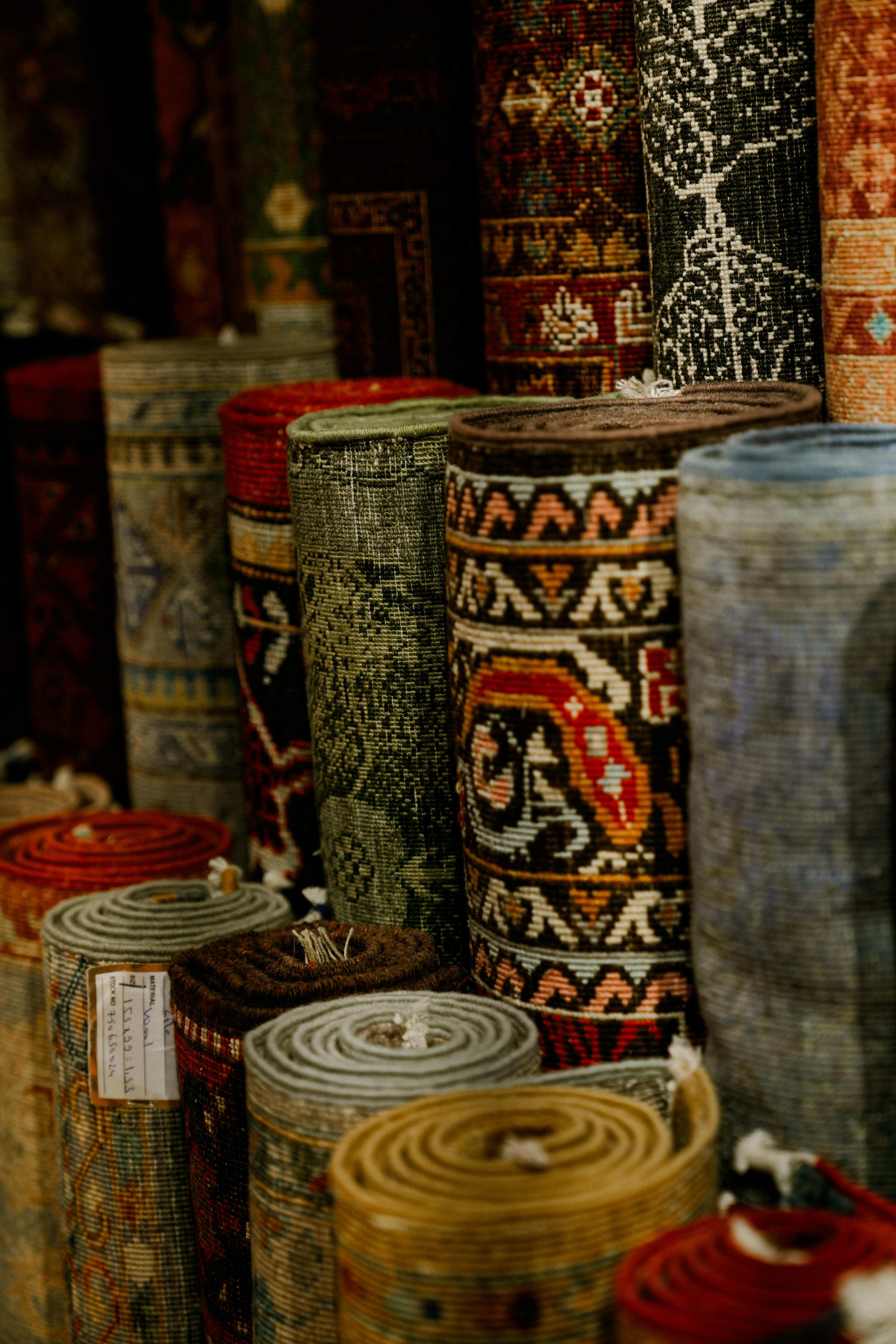 Colorful Rolled Rugs Displayed in Market · Free Stock Photo