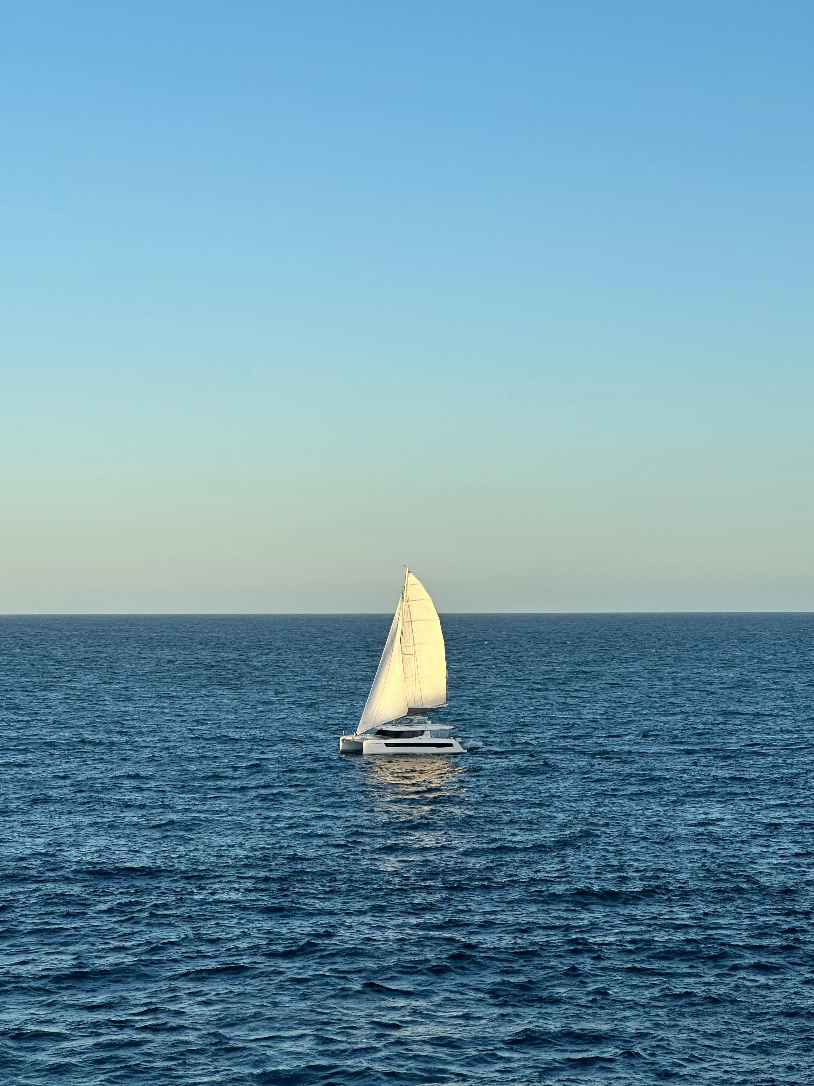 Sailboat Navigating Pacific Ocean at Dusk · Free Stock Photo