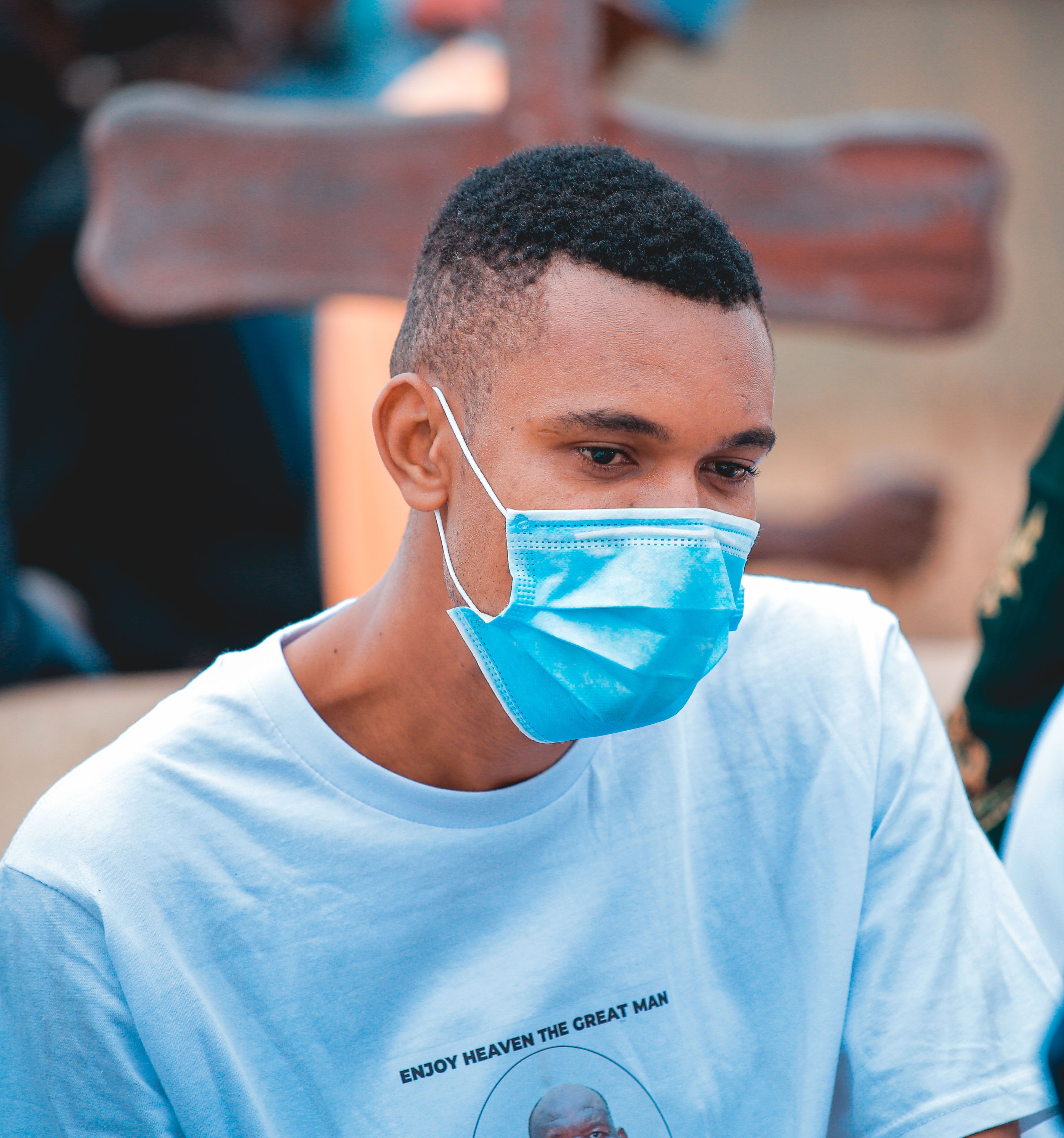 Young Man Wearing Mask at Outdoor Event · Free Stock Photo